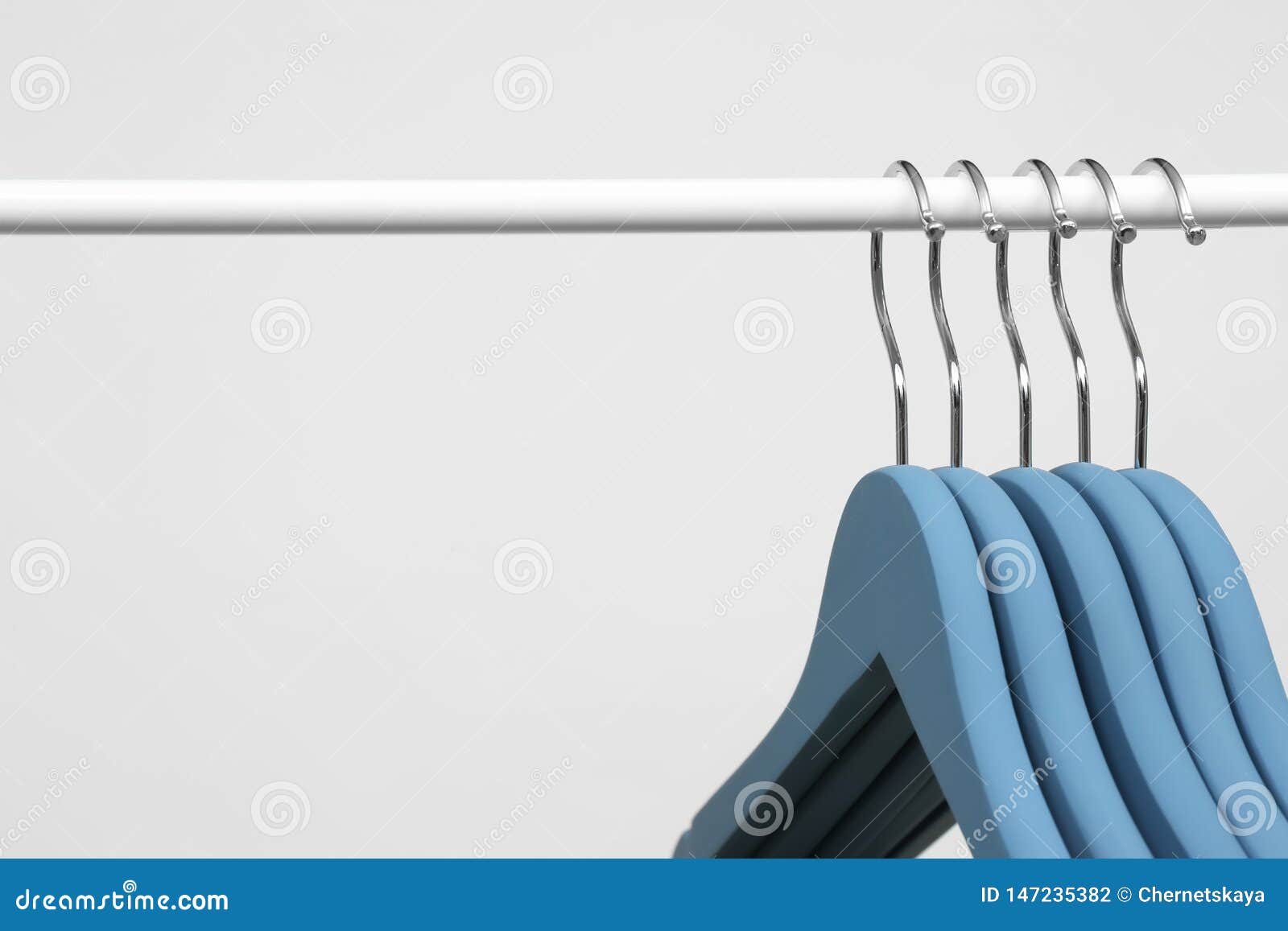 Empty Clothes Hangers on Metal Rail Against Light Background, Closeup ...