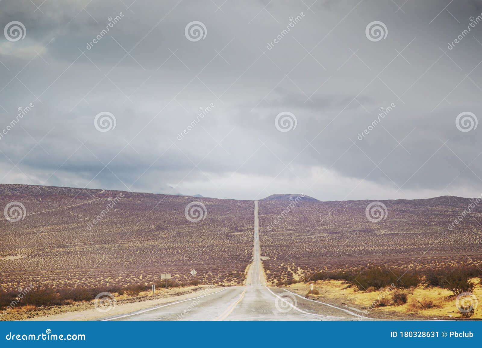 Empty Desert Road With Open Sky And Distant Mountains In Nevada Royalty ...
