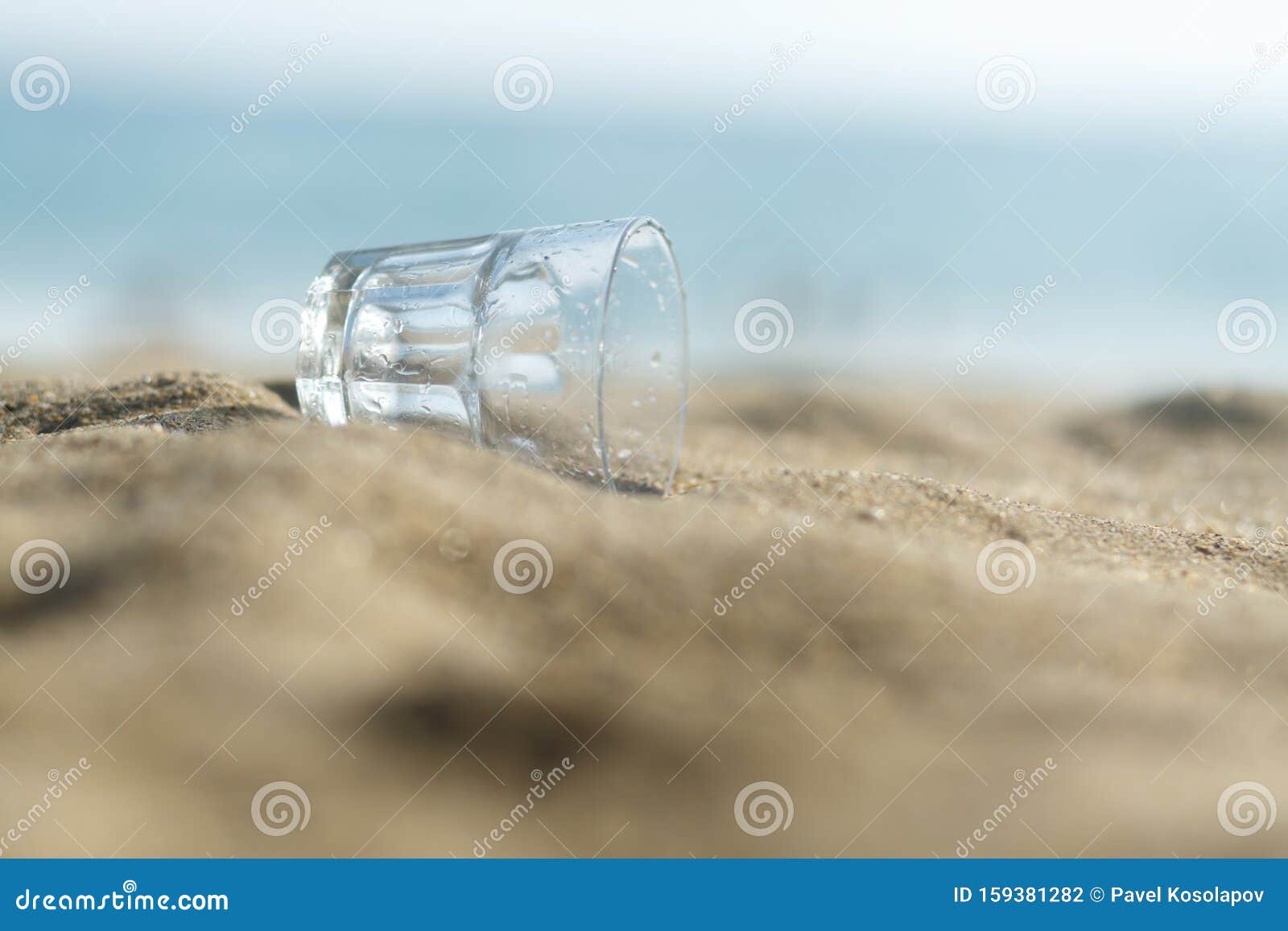 Empty glass Cup on sand stock photo. Image of brown - 159381282