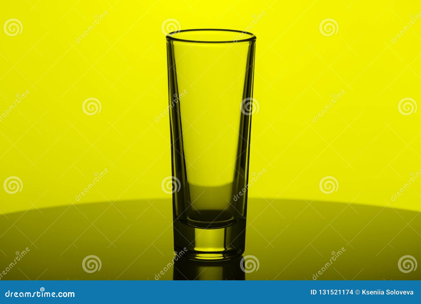 Empty Glass for Vodka on a Reflective Surface on a Yellow Background ...