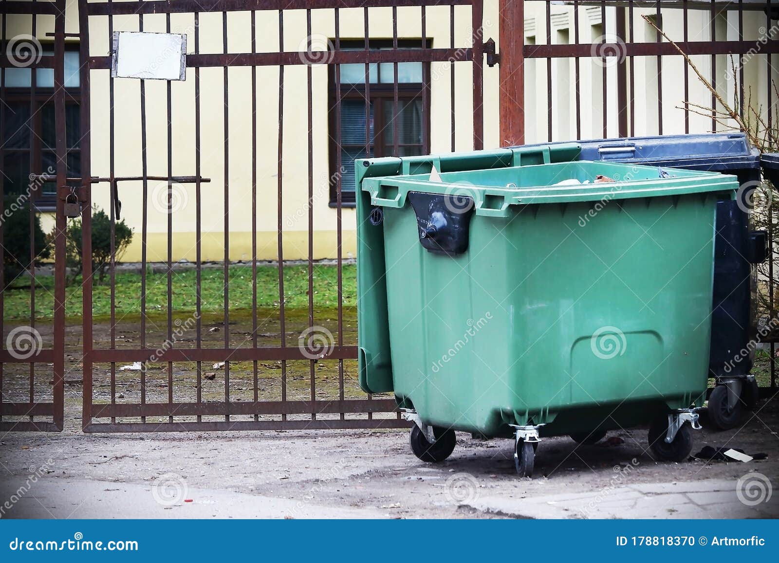 Empty Green Plastic Garbage Container Standing in Front of Locked Gates ...
