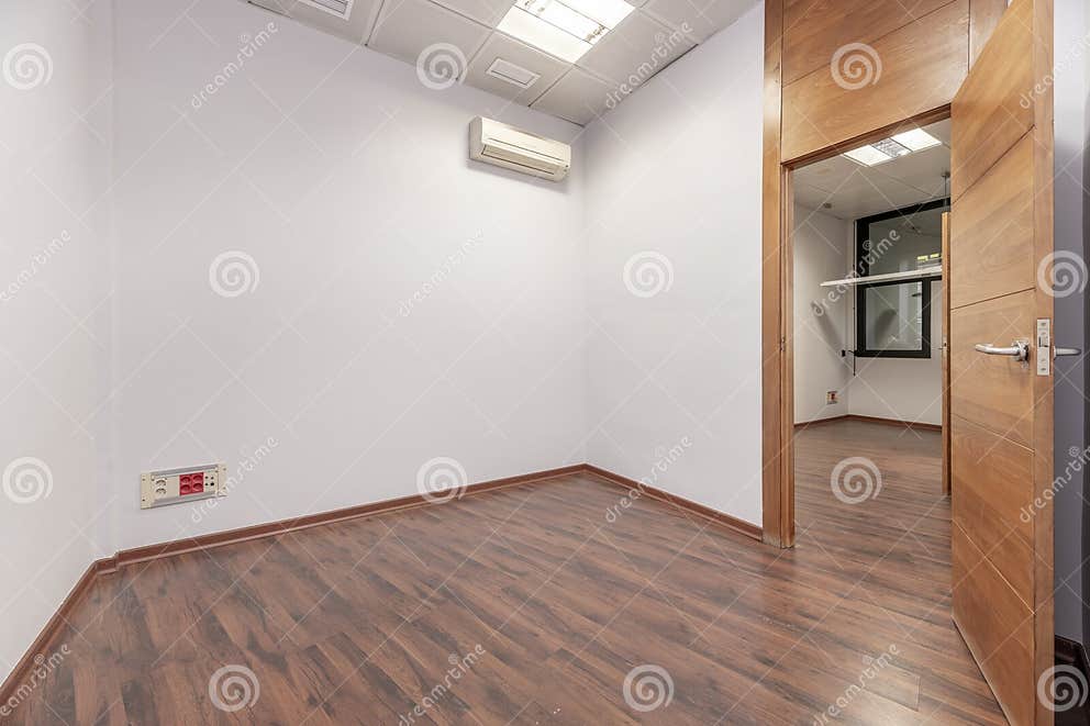 An Empty Office with Plain White Painted Walls, Reddish Parquet Floors ...