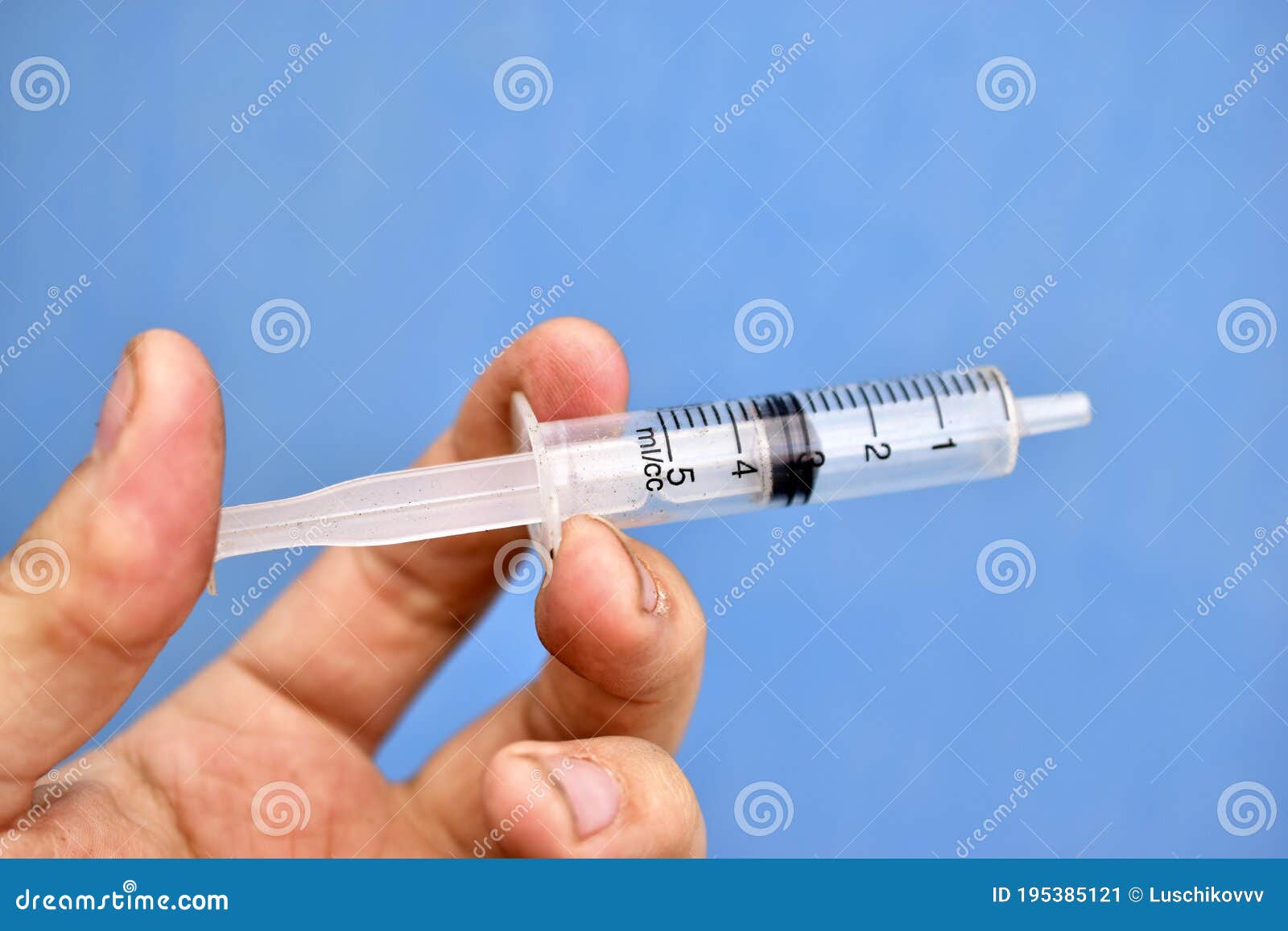 Empty Plastic Syringe with No Needle in Hand on a Blue Background Stock ...