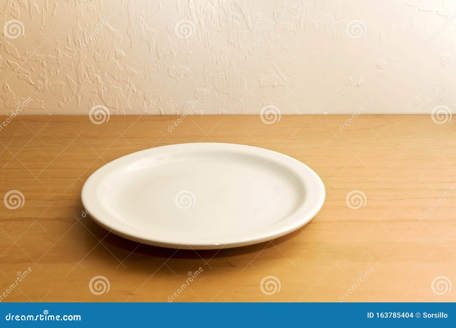 Empty Plate on Wooden Counter Against Wall Stock Photo - Image of plate ...