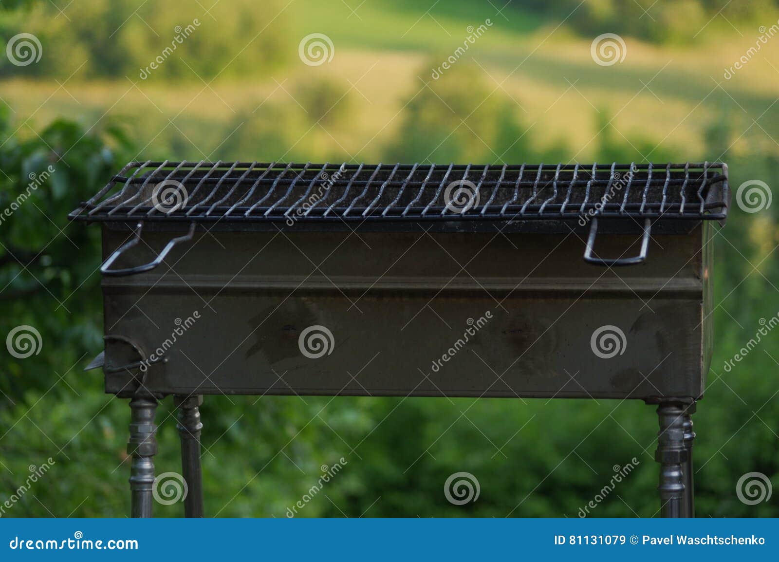 Empty Portable BBQ Grill in Front of a Fresh Green Summer Landscape ...