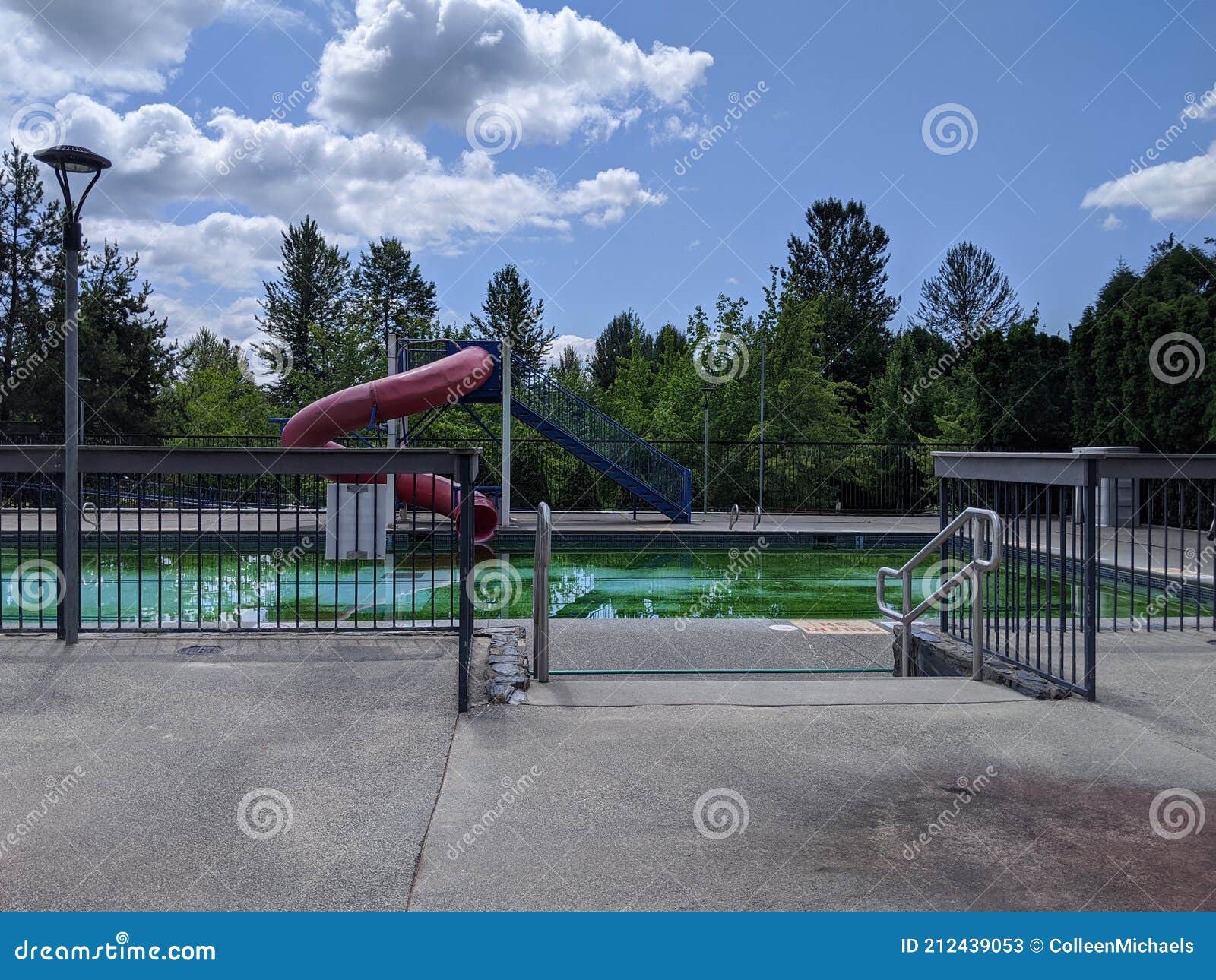 An Empty Public Pool with a Large, Red Waterslide on a Bright, Sunny ...