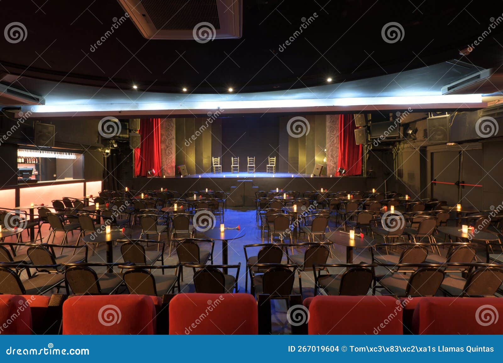 An Empty Theater with Stalls with Tables and a Stage with Four Chairs ...