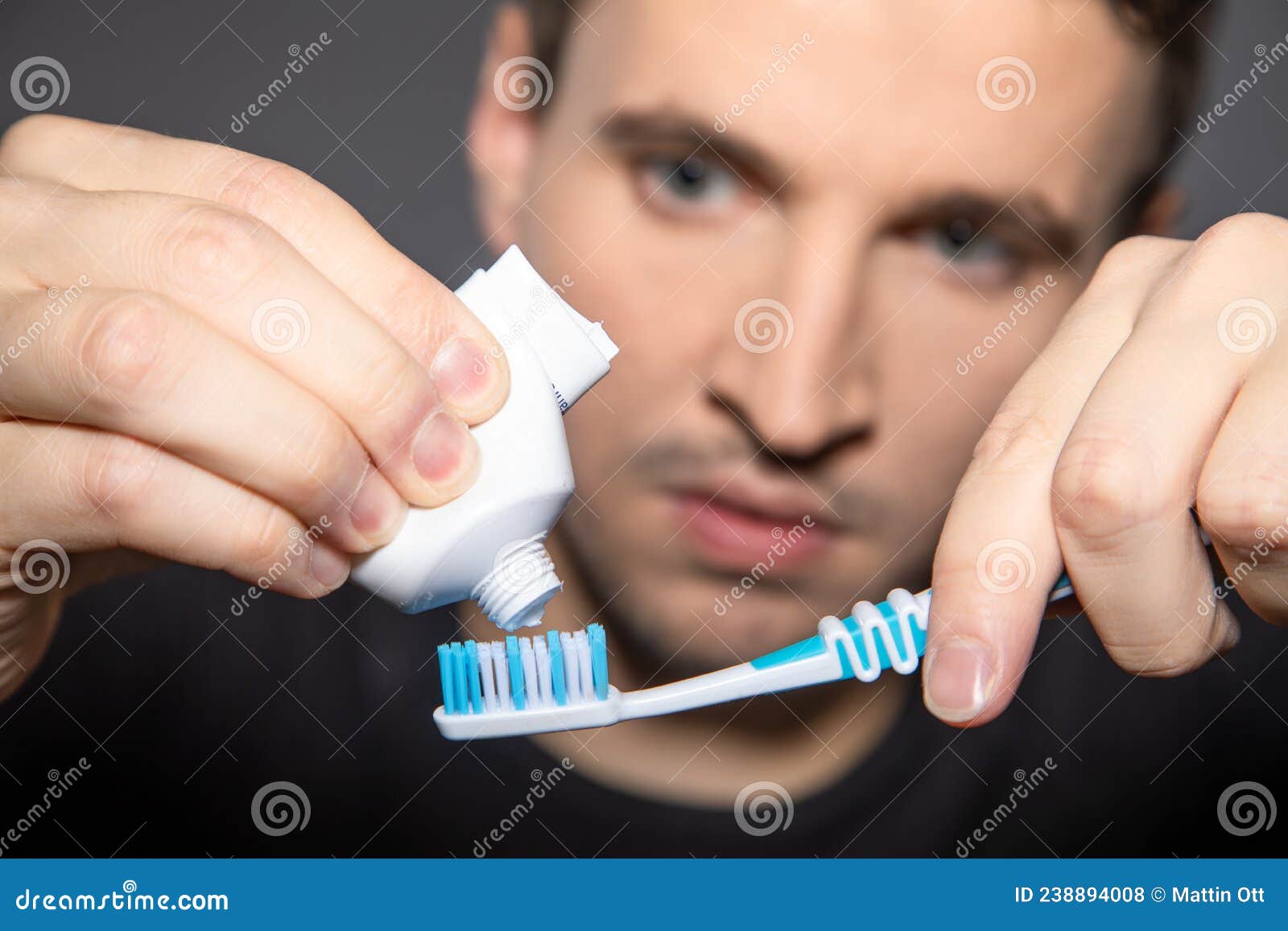 Empty Tube of Toothpaste with Man in Background Squeezing the Container ...