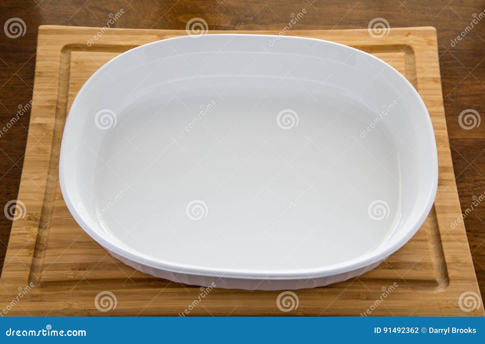 Empty White Casserole Dish on Wood Cutting Board Stock Photo - Image of ...