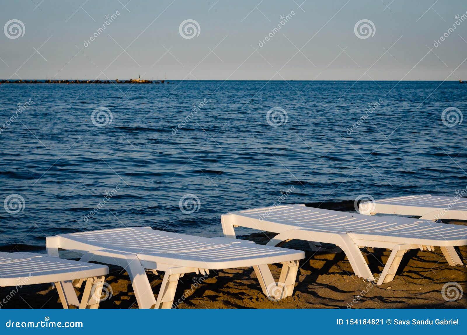 Empty White Plastic Sunbeds Set on the Seashore. Stock Image - Image of ...