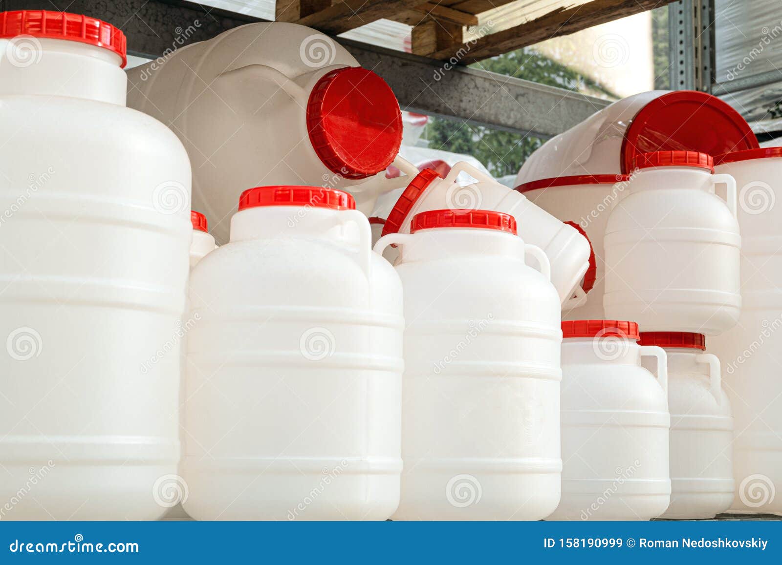 Empty White Plastic Water-cans with Red Lids on a Rack Stock Image ...