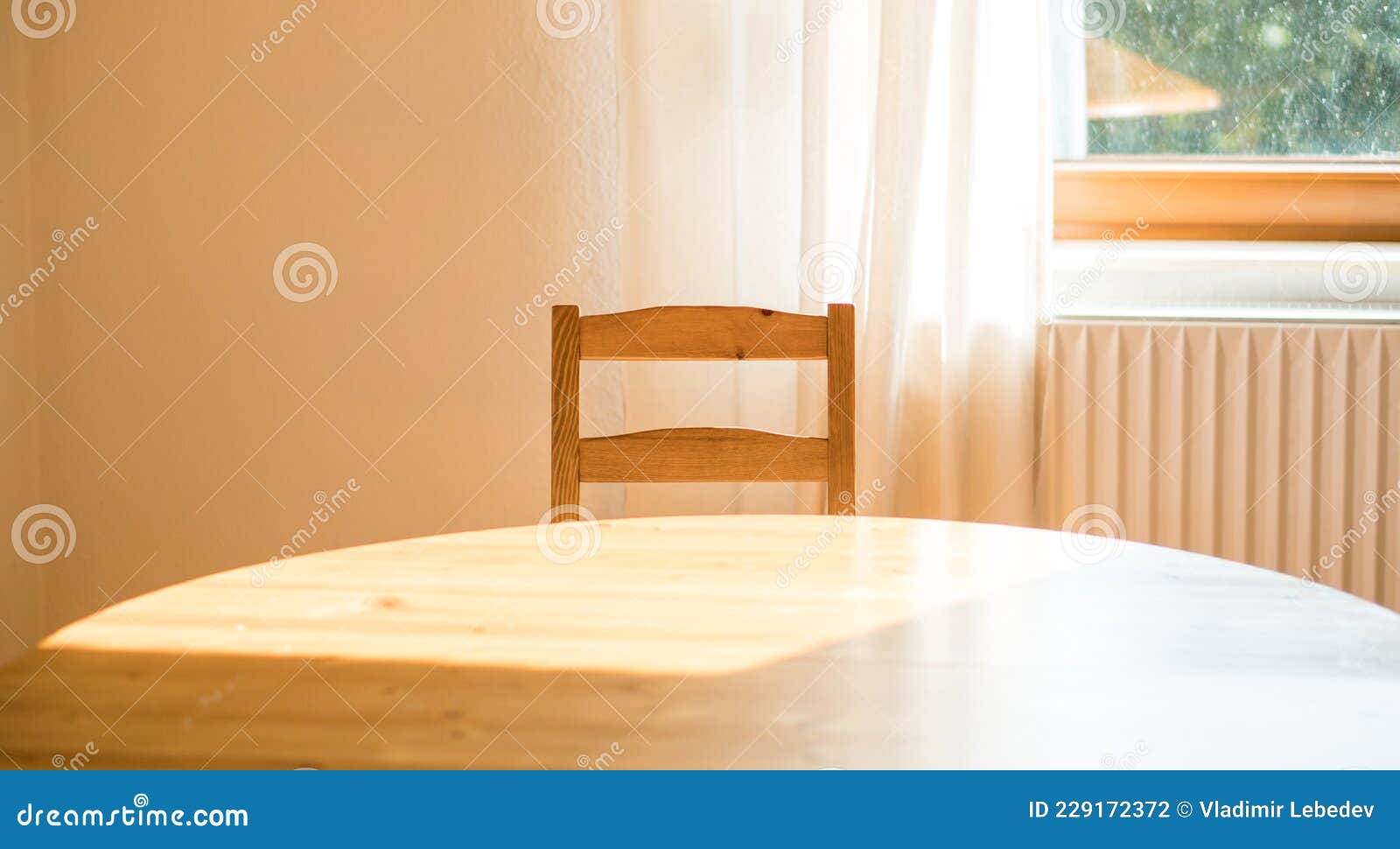 An Empty Wooden Chair by a Wooden Table, Illuminated by the Light of ...