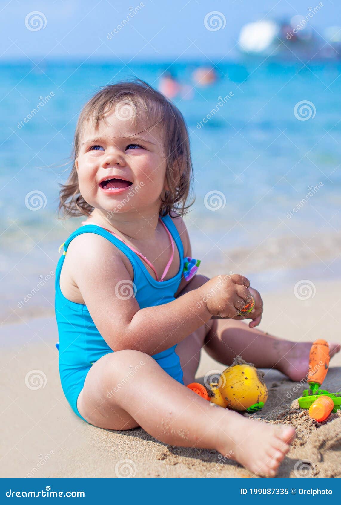 En Glad Flicka Som Leker Med Sand Och Leksaker På Stranden