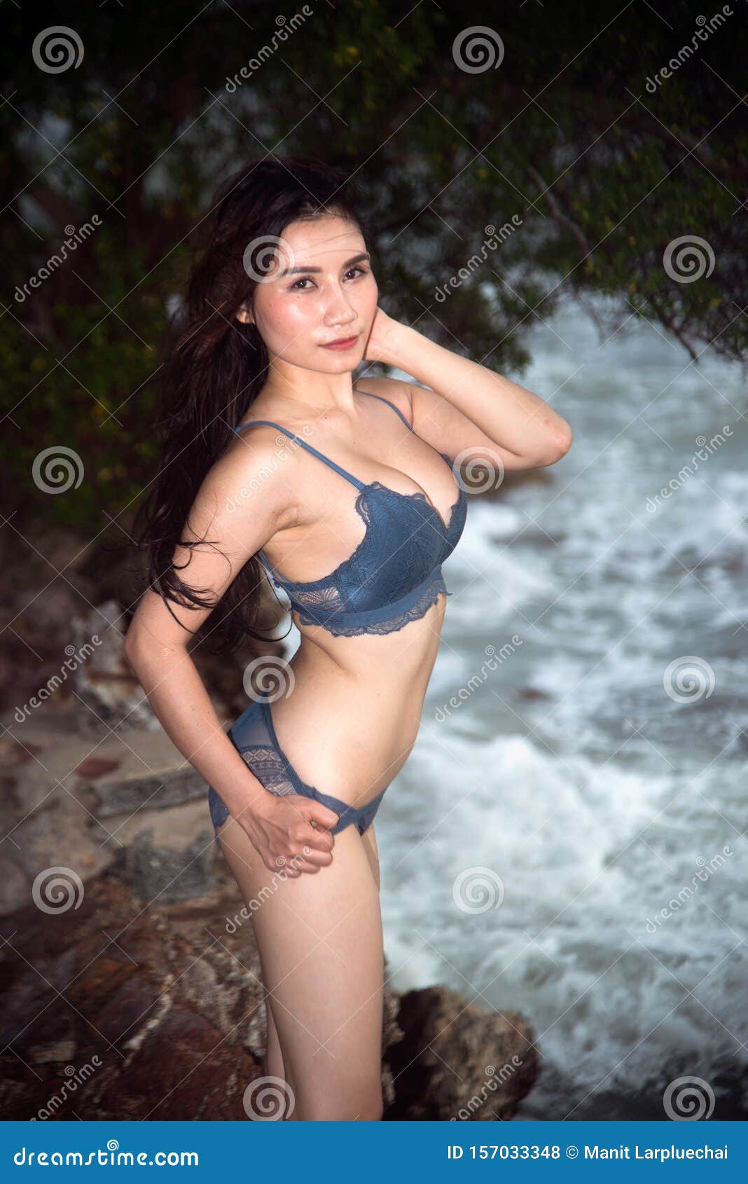 En Vacker Asiatisk Kvinna I Blå Bikini Som Står På Stranden Arkivfoto