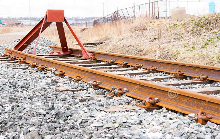A Red Railway Stopper the the End of Some Old, Rusty Train Tracks Stock ...