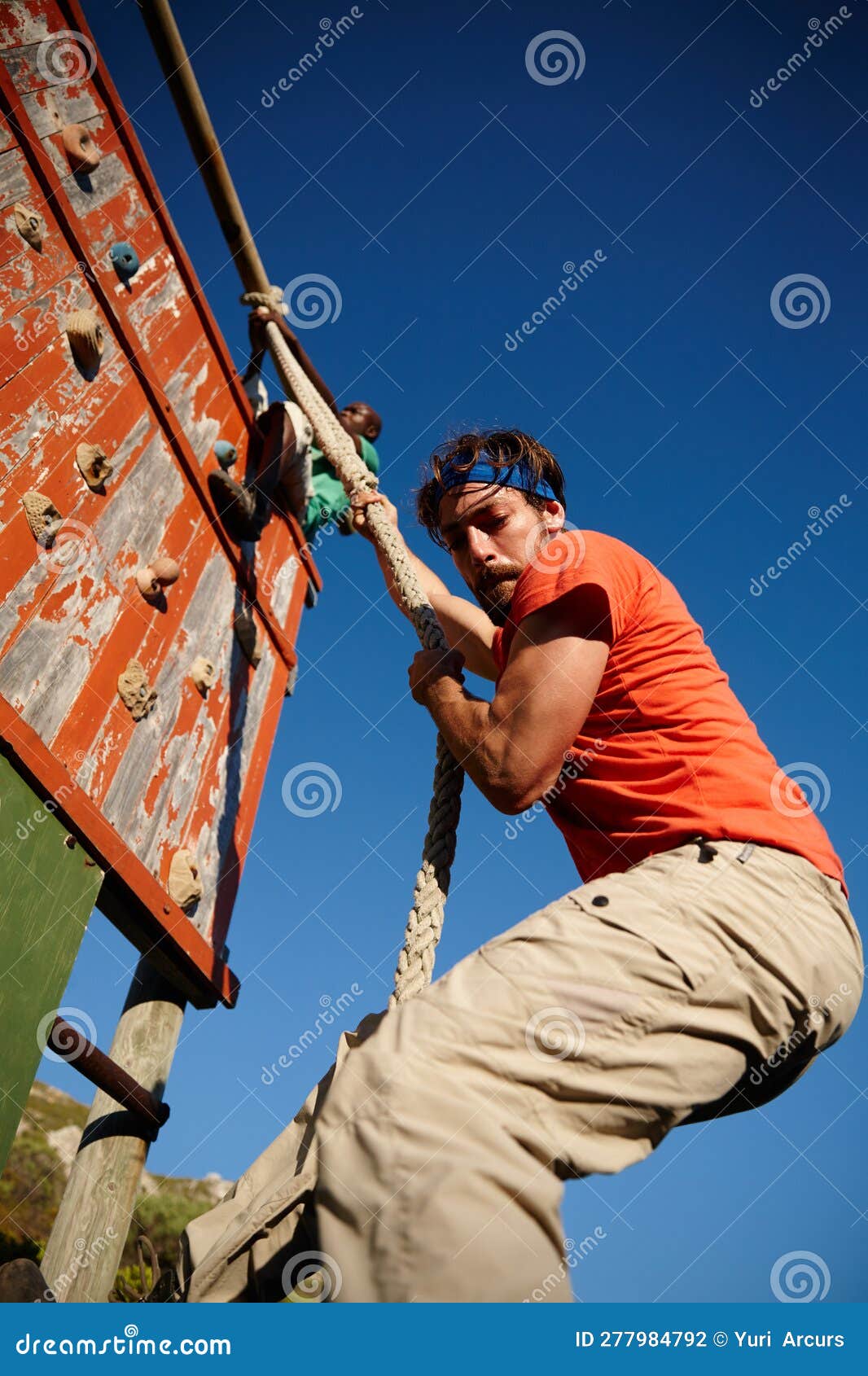 Endure and Conquer. a Young Man Climbing Over an Obstacle at Military ...