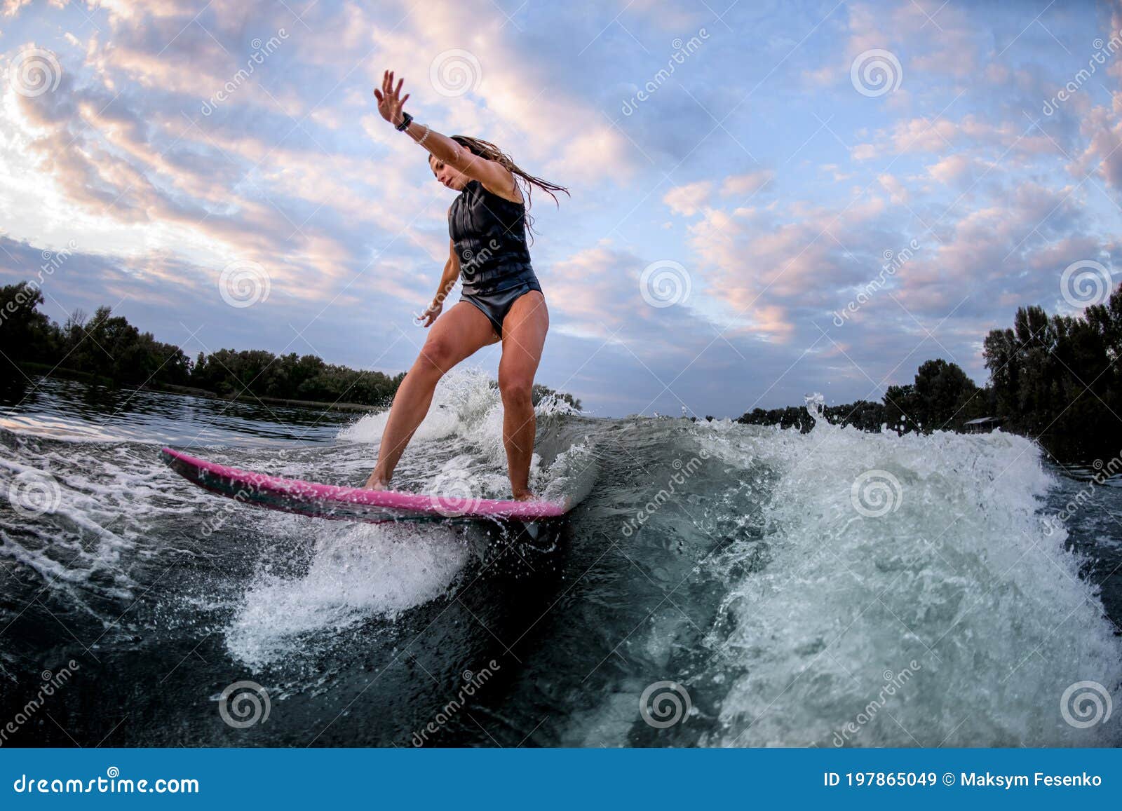 Energetic Young Woman Stands On Surf Style Wakeboard And Balances On