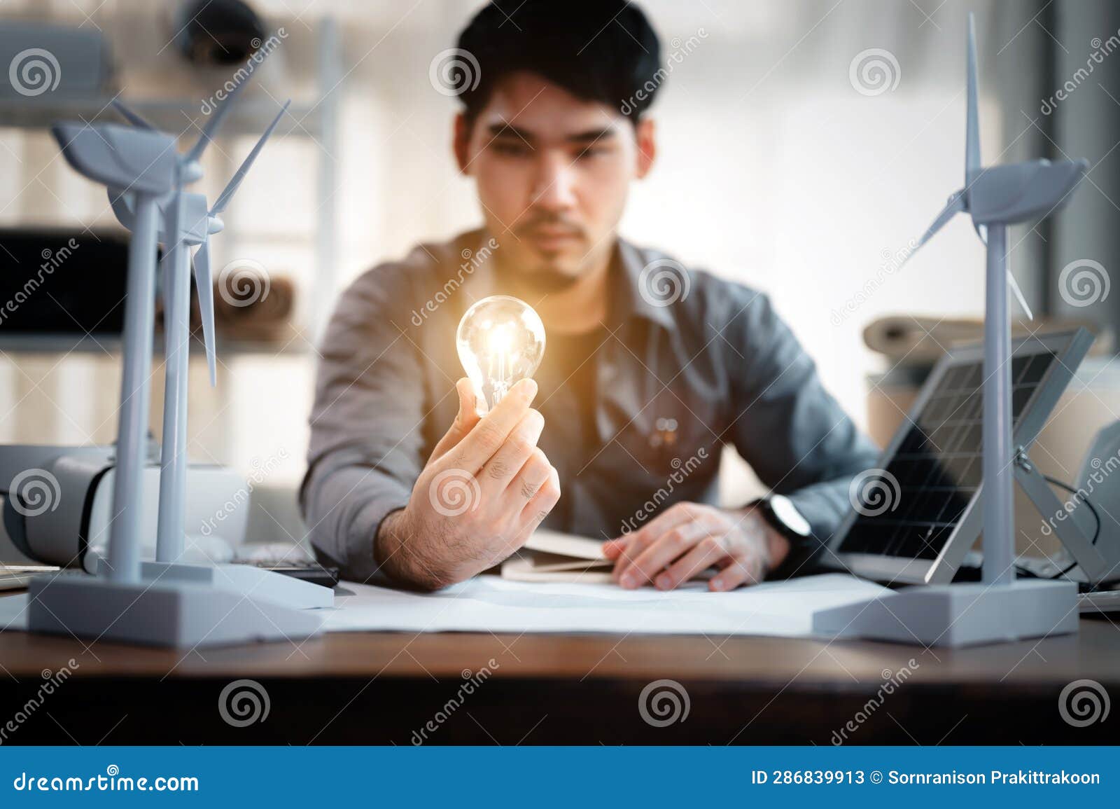 Energy Engineer Holding Light Bulb in Modern Office with Solar Cell ...