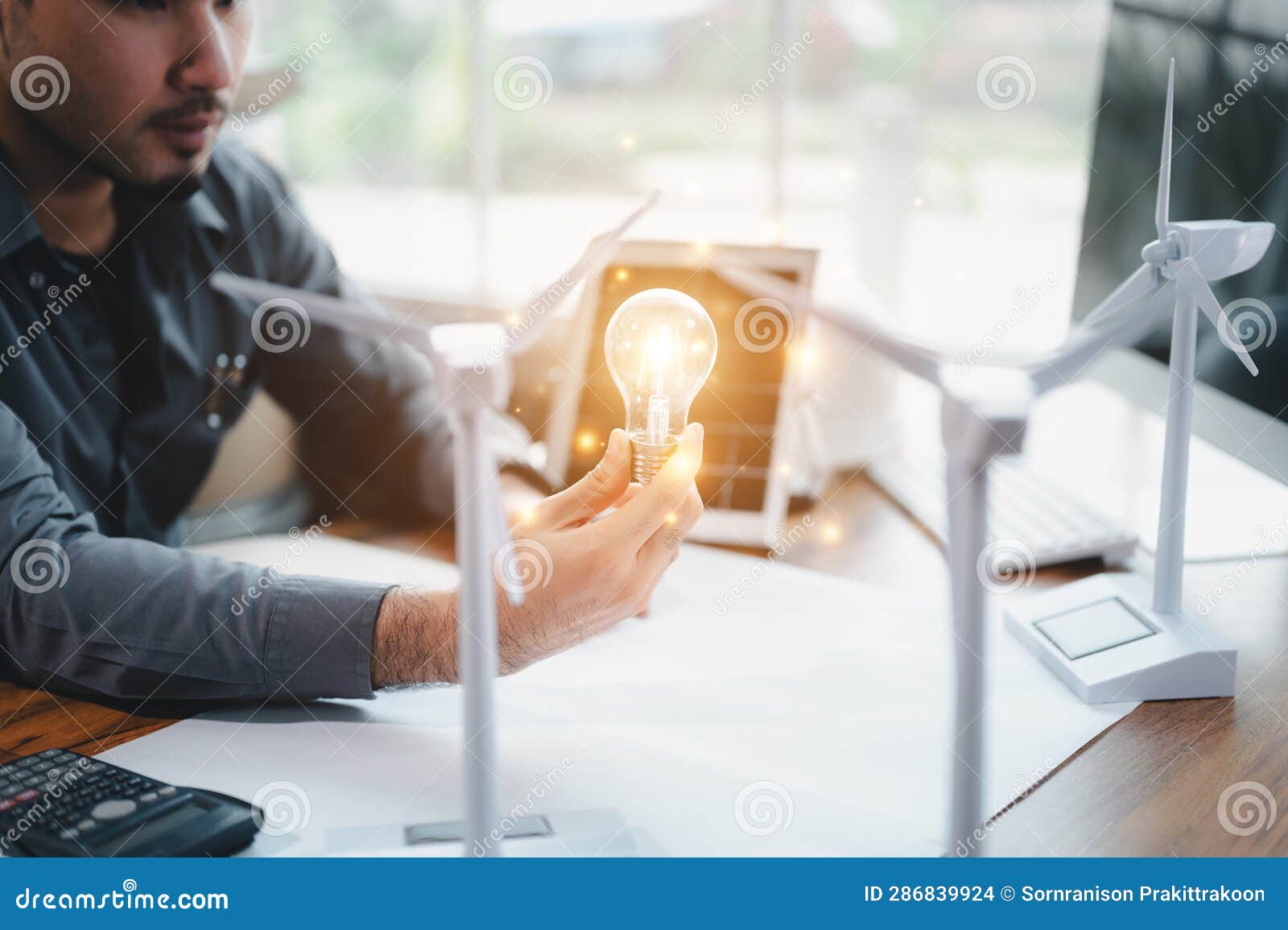Energy Engineer Holding Light Bulb in Modern Office with Solar Cell ...