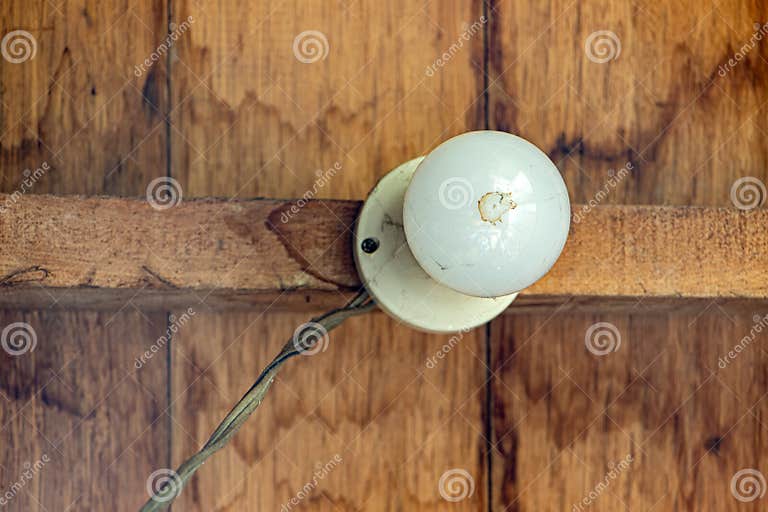 A Energy-saving Light Bulb in a Socket Fixed on the Wooden Ceiling ...