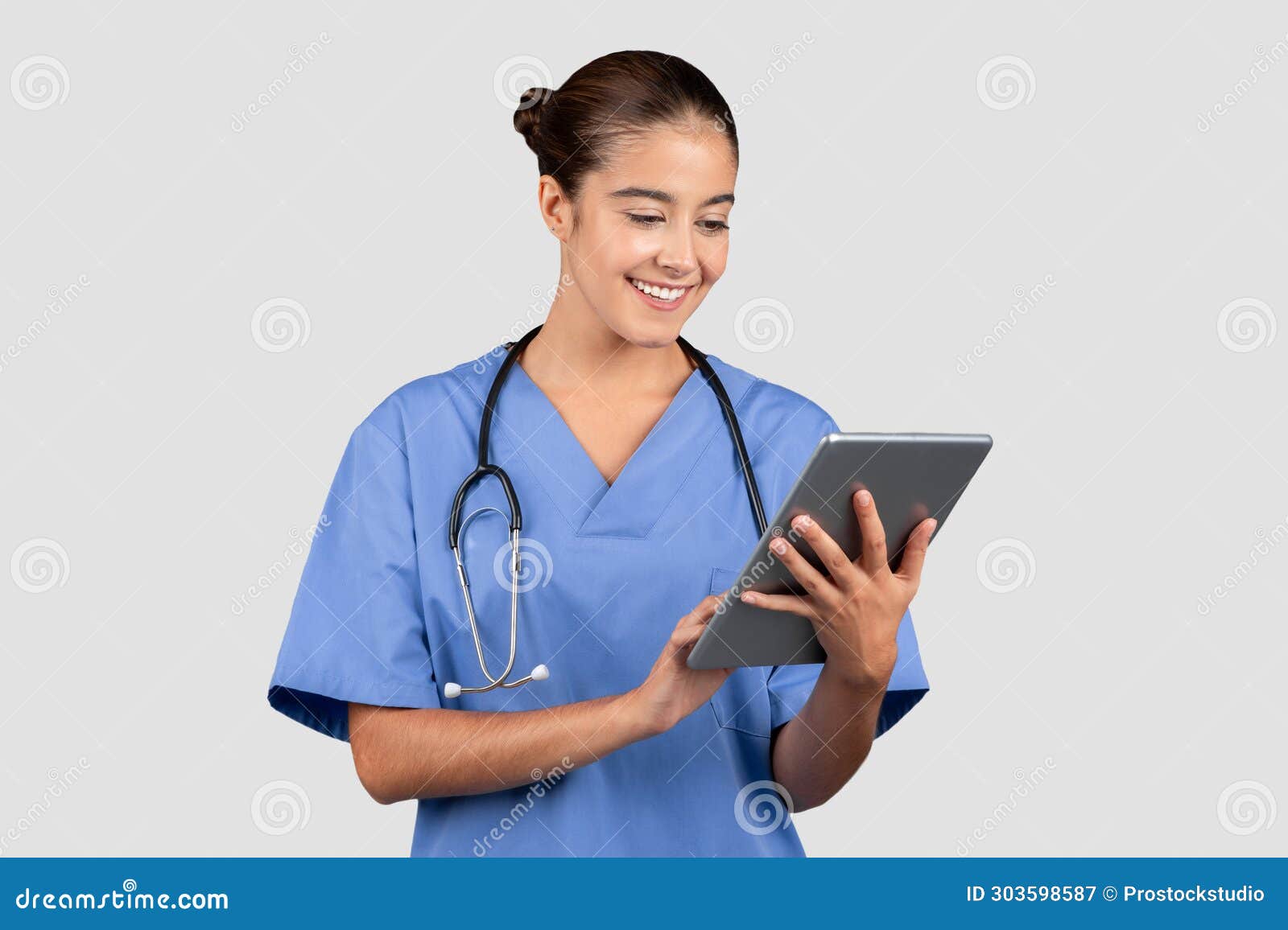 Engaged and Friendly European Nurse in Blue Scrubs Focused on Browsing ...