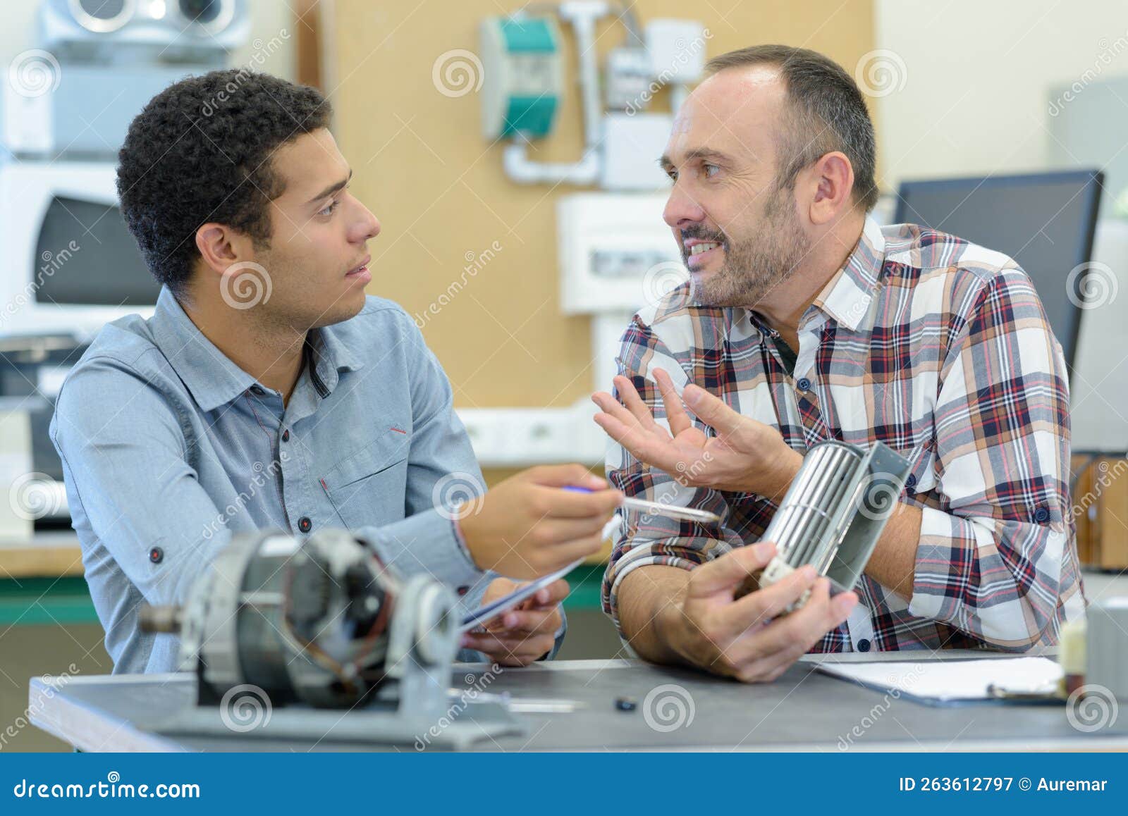 Engineer and Apprentice Examining Component in Office Stock Image ...