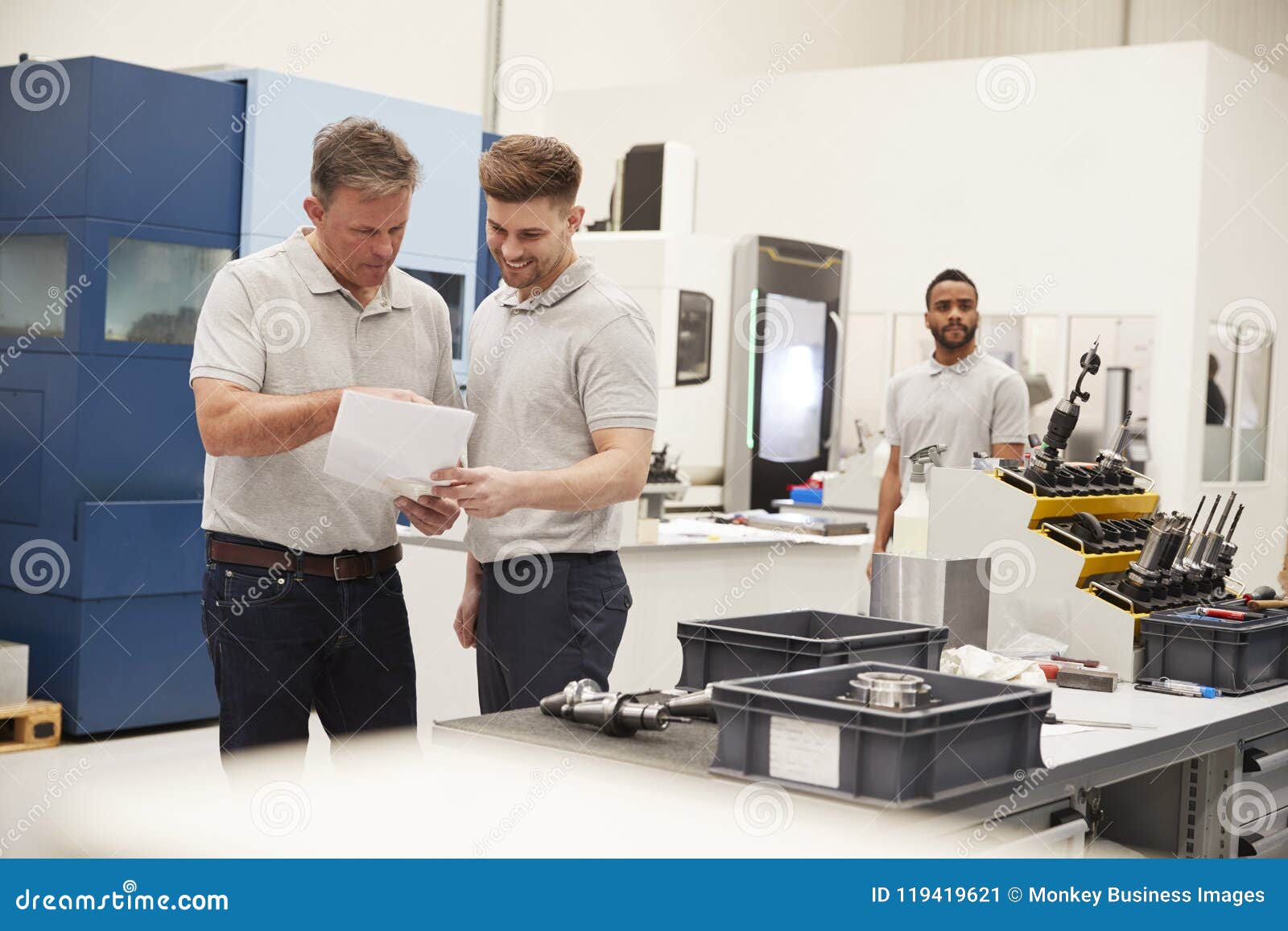 Engineer and Apprentice Meet on Floor of Engineering Workshop Stock ...