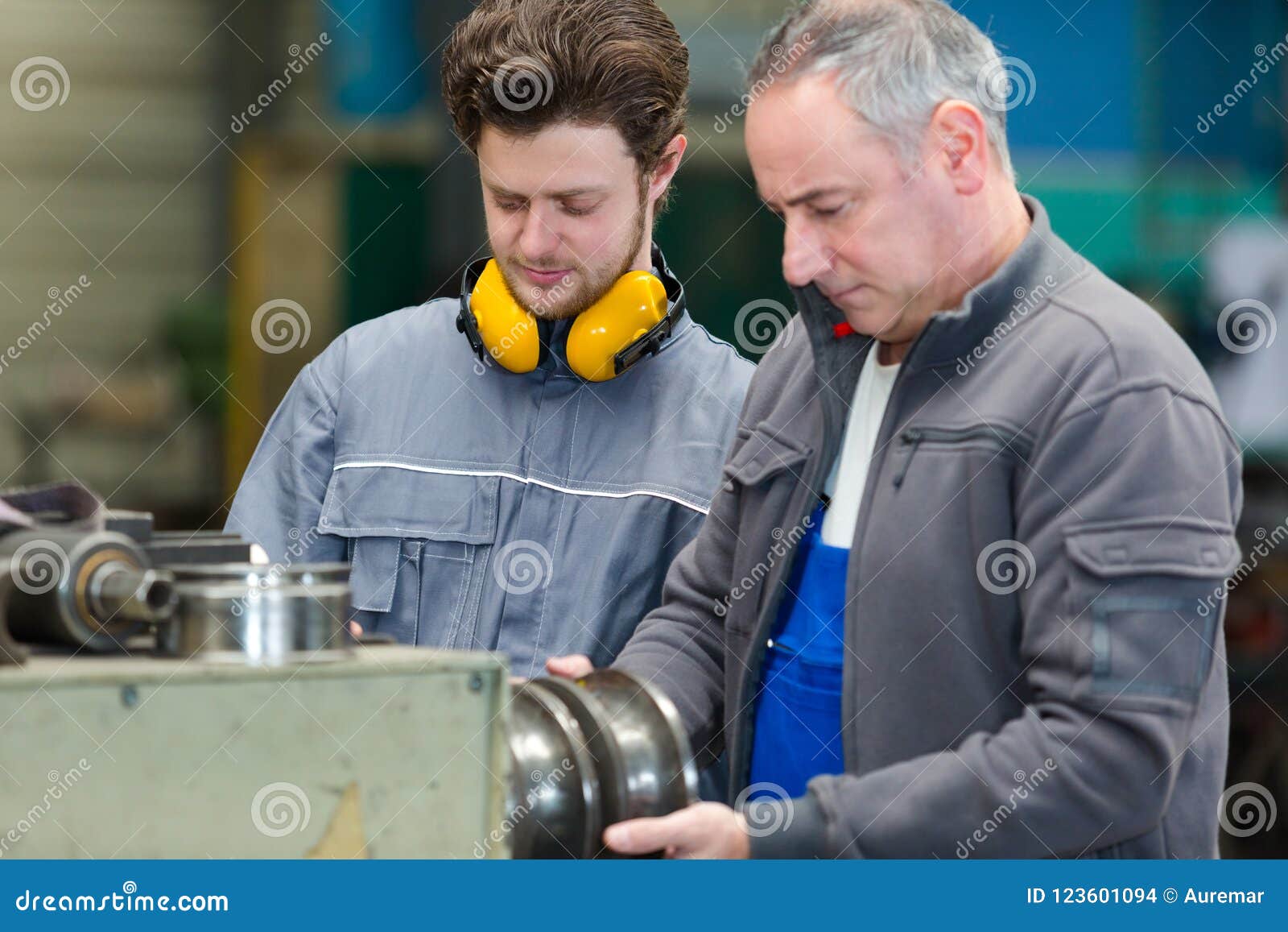 Engineer and Apprentice Using Machinery in Factory Stock Photo - Image ...