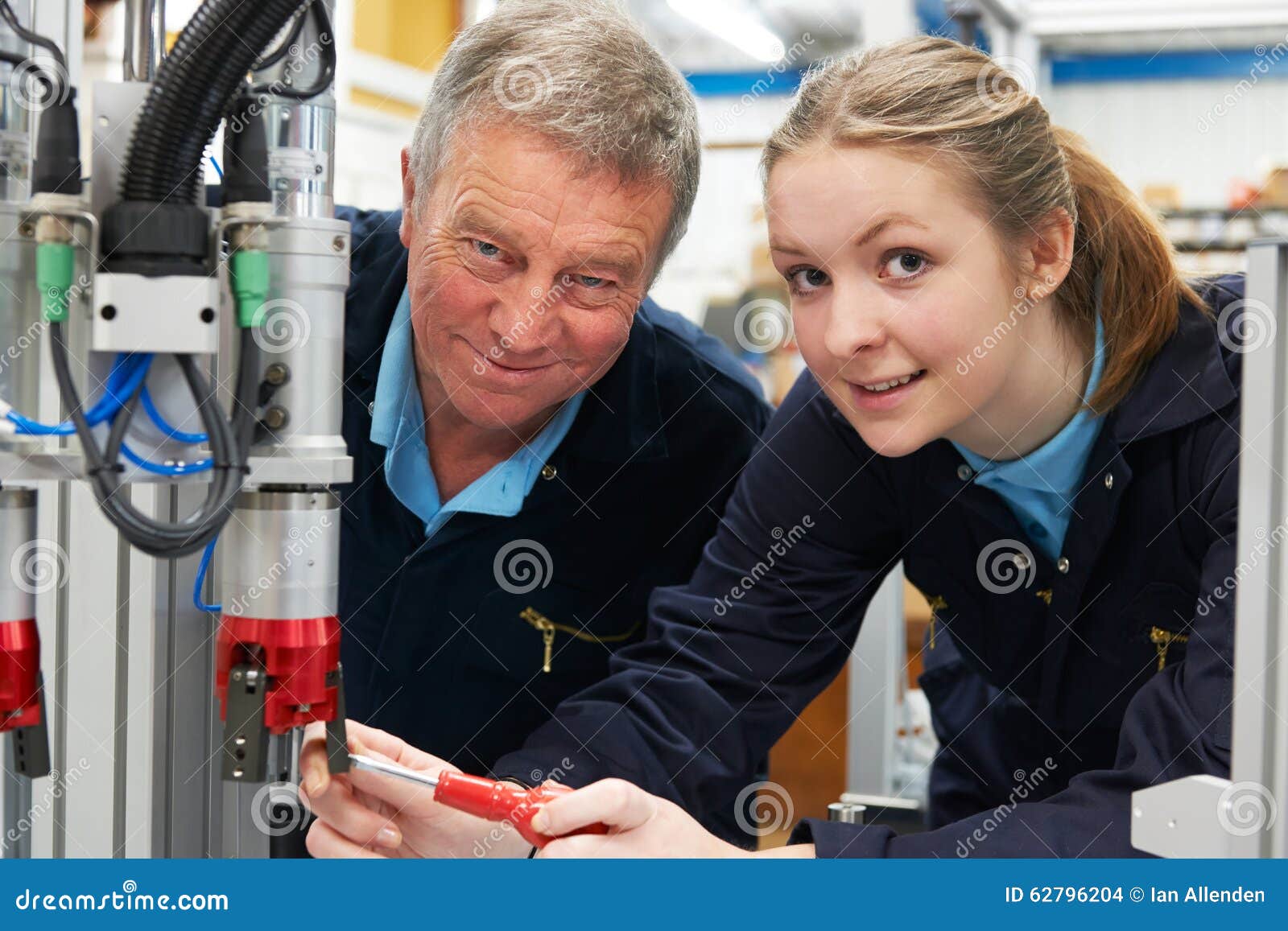 Engineer and Apprentice Working on Machine in Factory Stock Photo ...