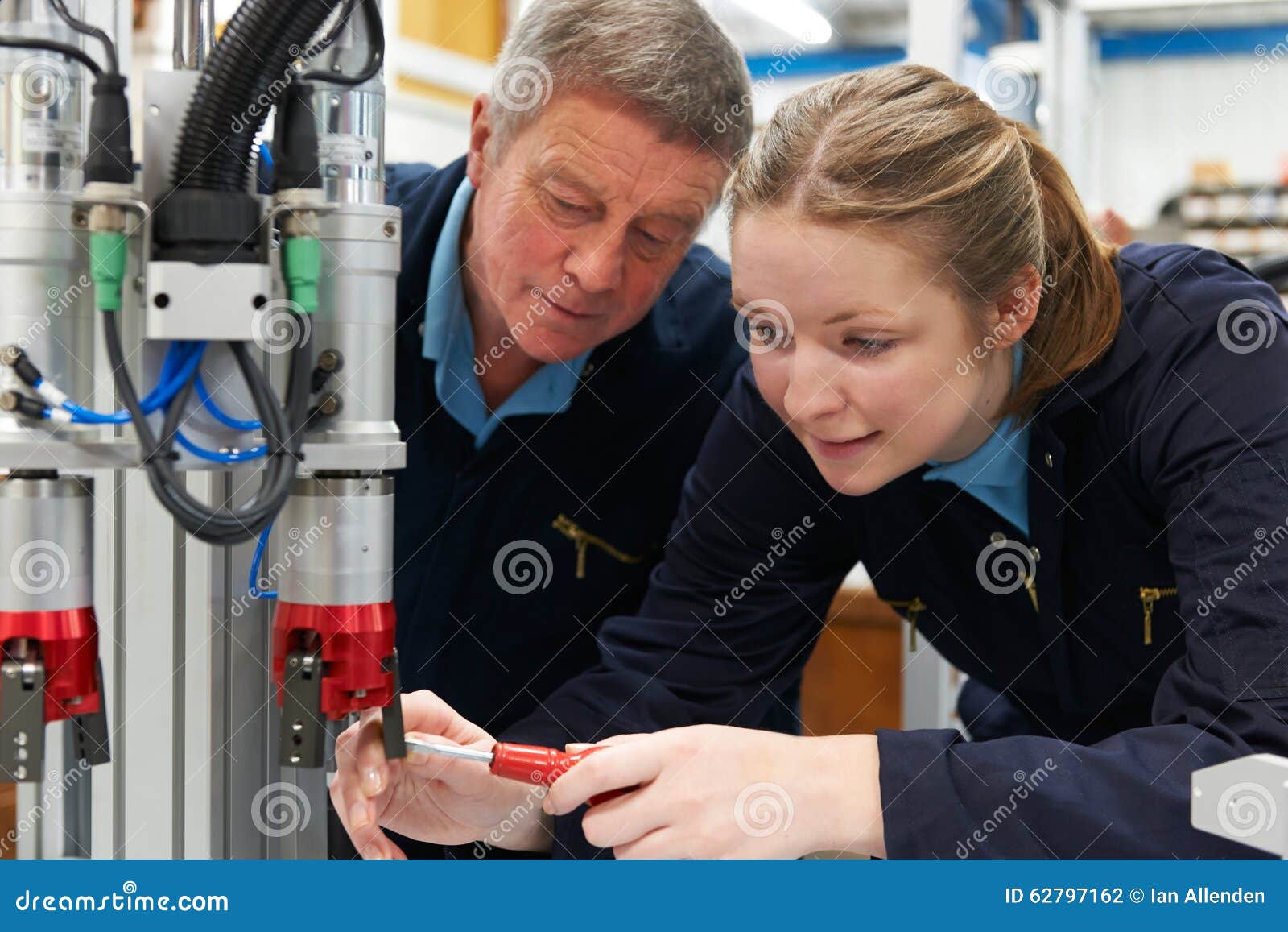 Engineer and Apprentice Working on Machine in Factory Stock Photo ...