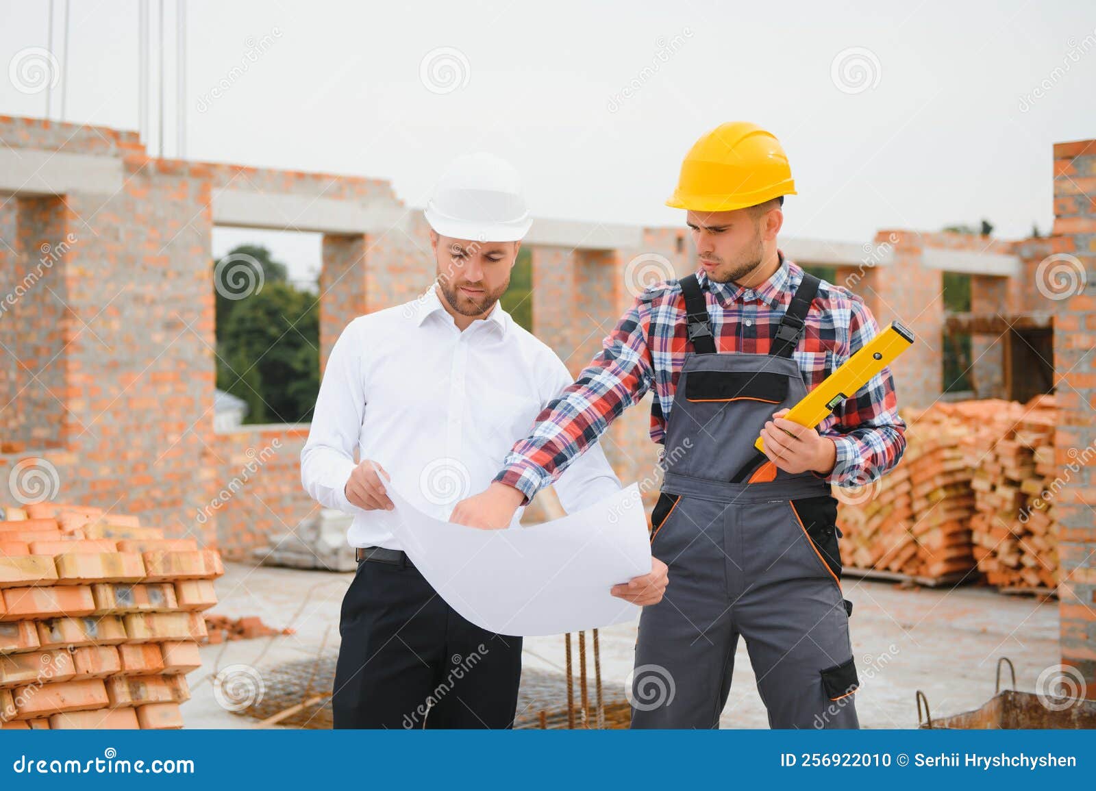 Engineer Architect with Hard Hat and Safety Vest Working Together in ...