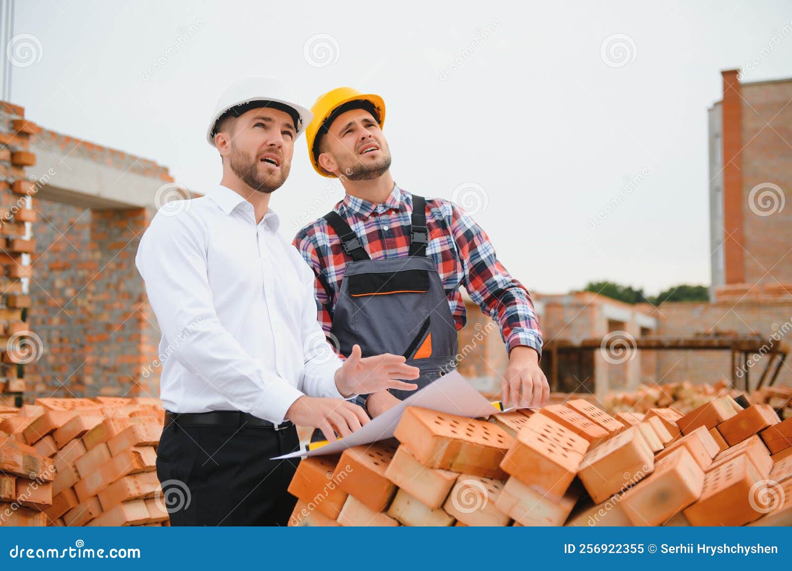 Engineer Architect with Hard Hat and Safety Vest Working Together in ...