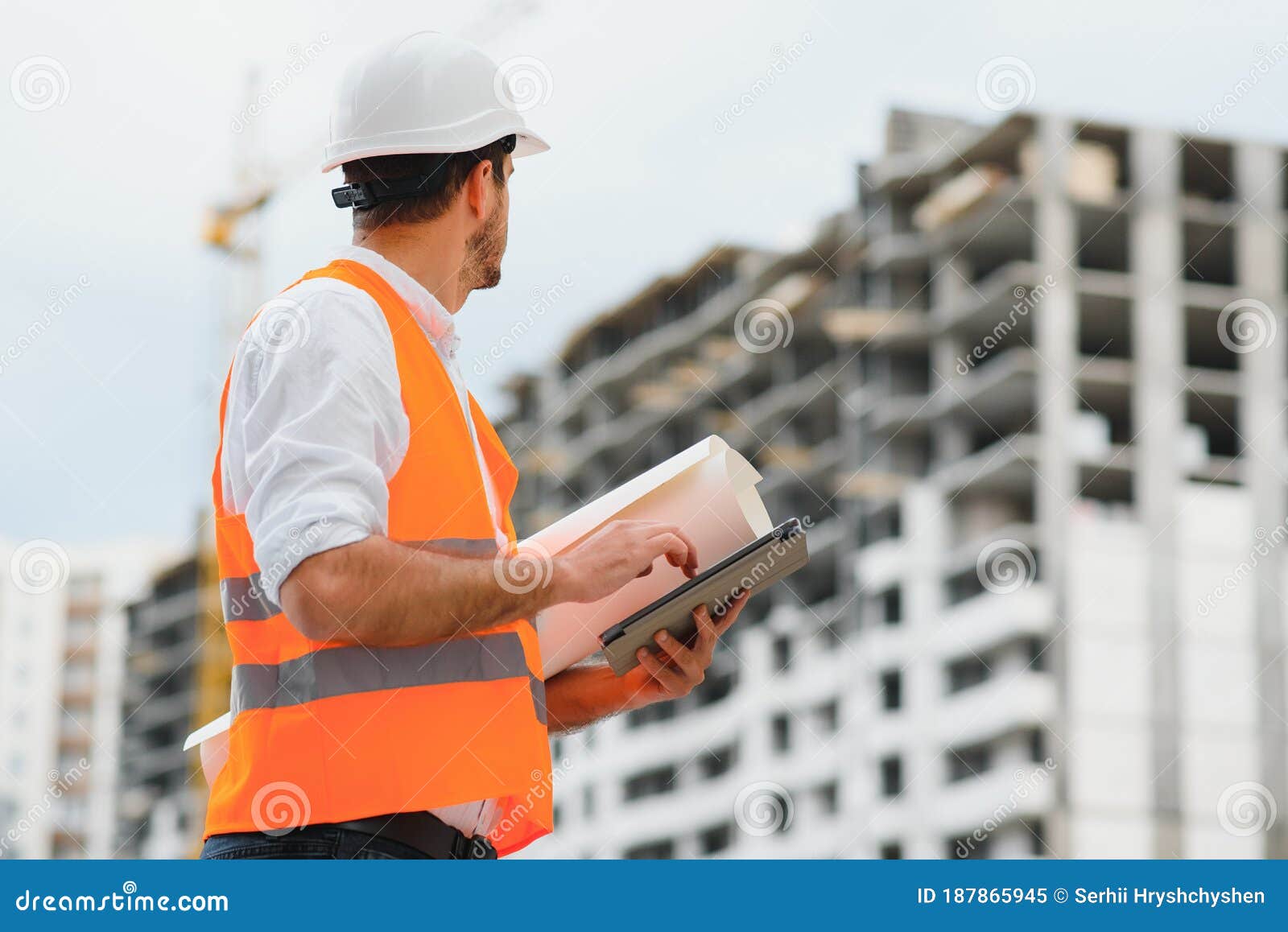 Engineer Builder Wearing Safety Vest with Blueprint at Construction ...