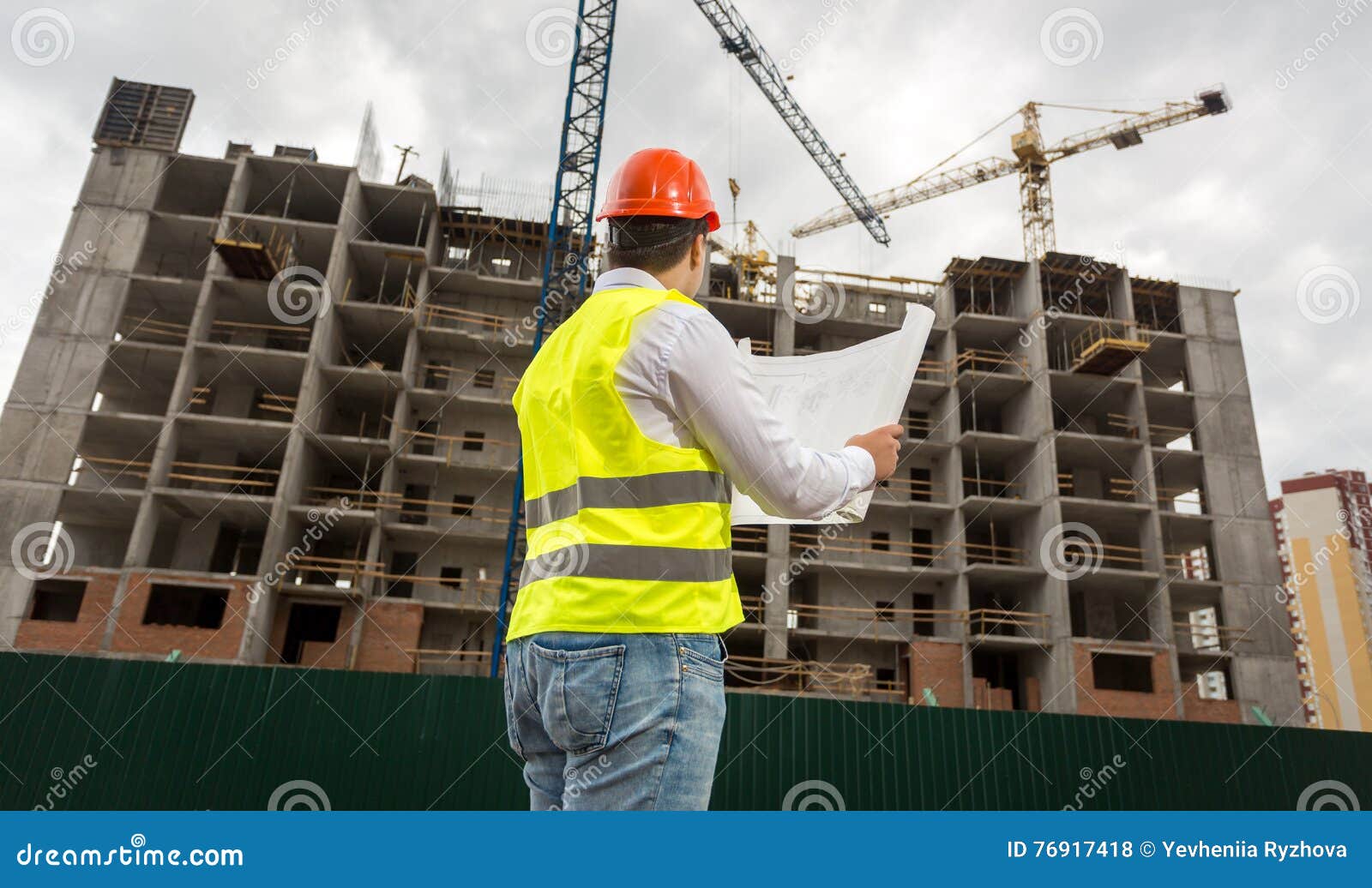 Engineer on Building Site Checking Plans and Blueprints Stock Photo ...