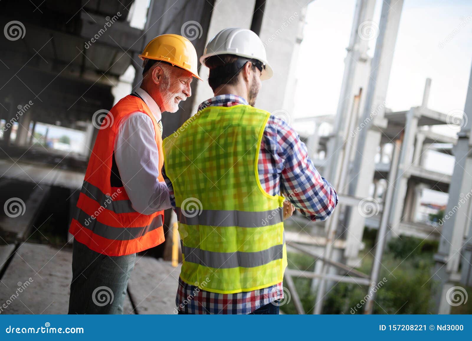 Engineer and Construction Site Manager Dealing with Blueprints and ...
