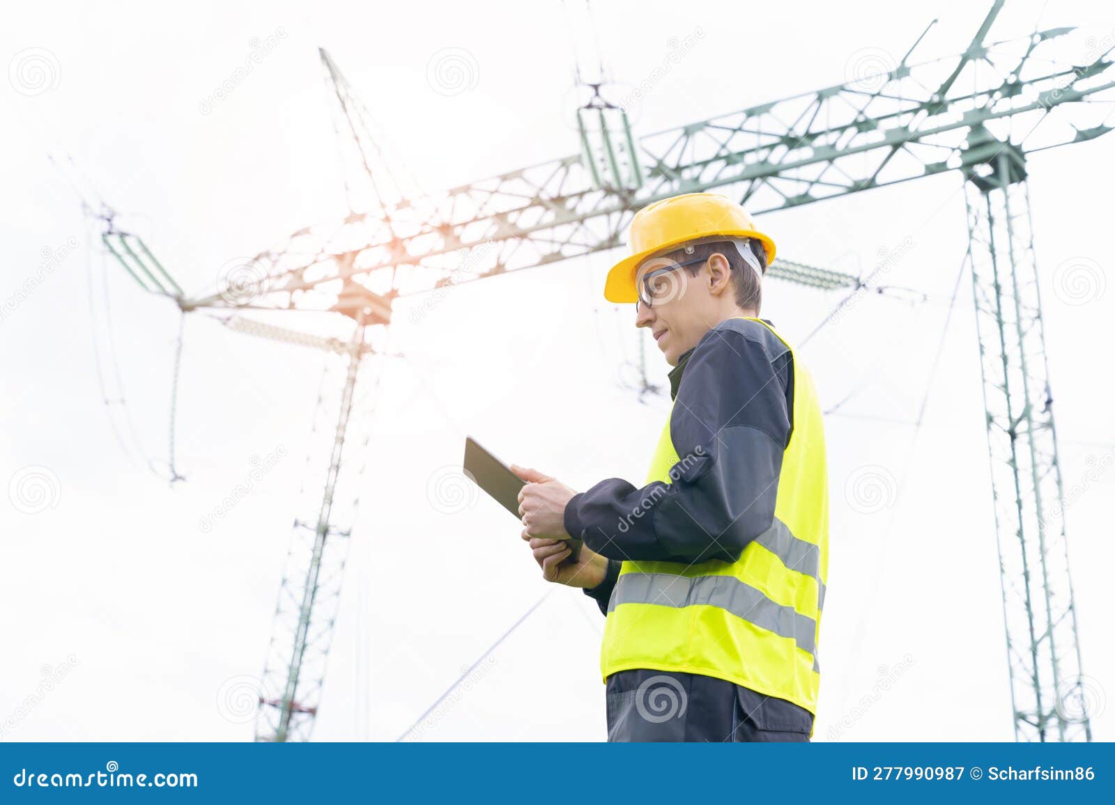 Engineer with Digital Tablet on a Background of Power Line Tower. Stock ...