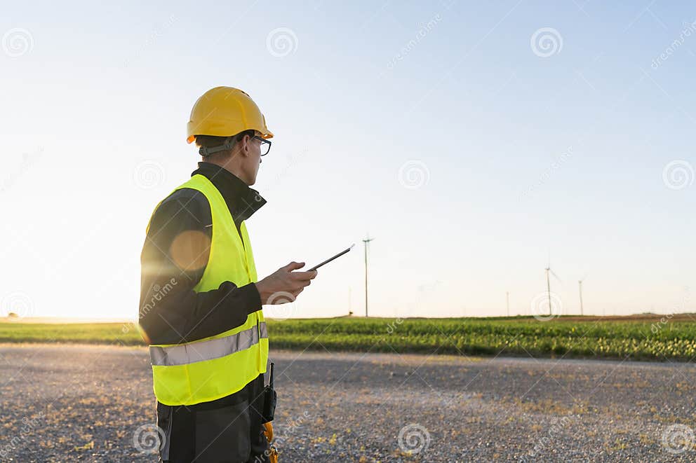 Engineer with Digital Tablet Works on a Field of Wind Turbines Stock ...