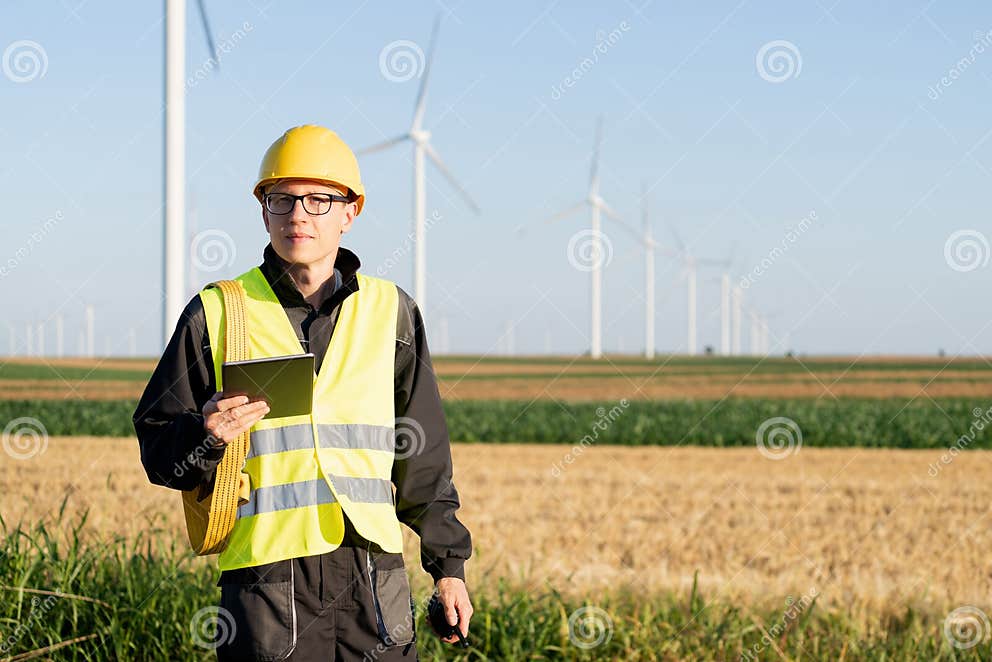 Engineer with Digital Tablet Works on a Field of Wind Turbines Stock ...