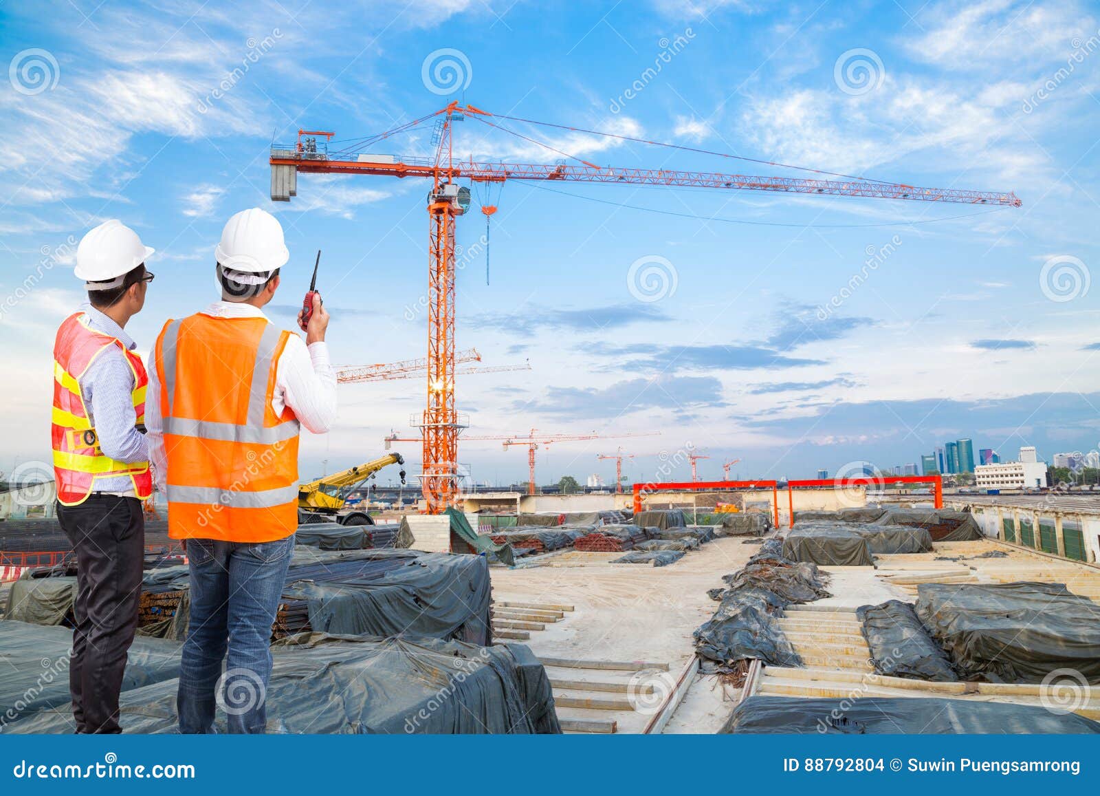 Engineer and Foreman Looking at Crane Construction with Talking Stock ...