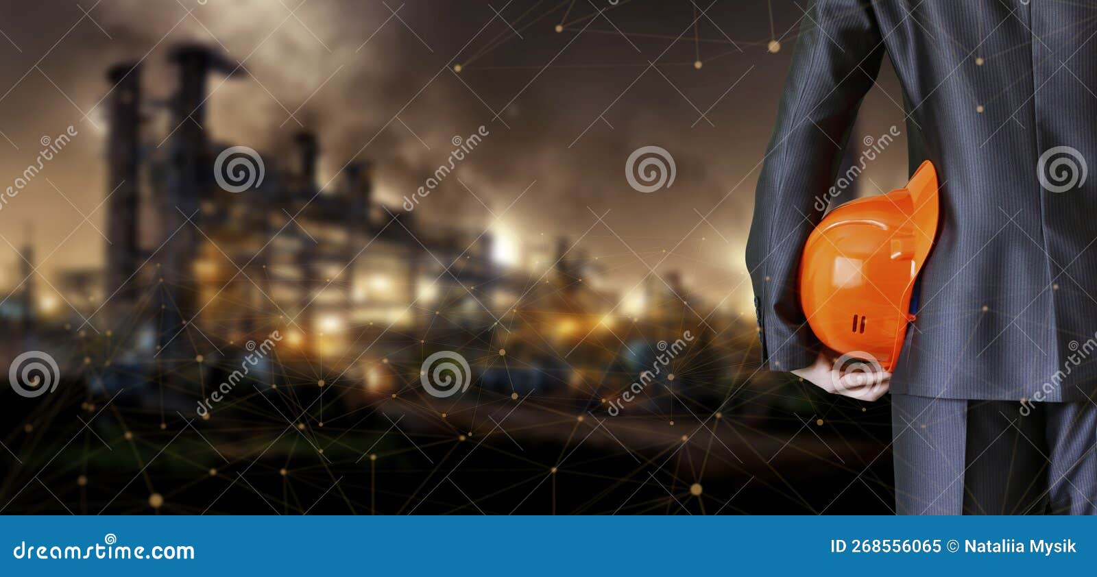 An Engineer with a Helmet in His Hands Stands in Front of Production ...