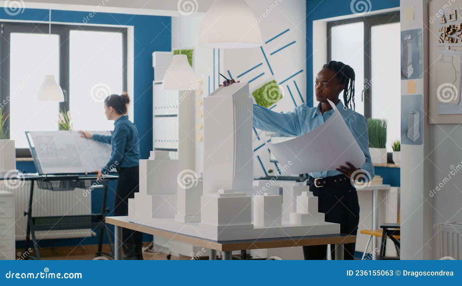 Engineer Holding Blueprints Plan and Analyzing Building Model for ...