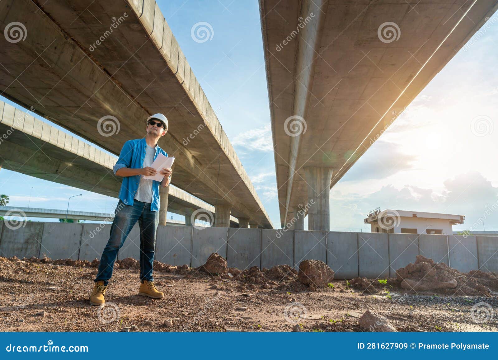 An Engineer Holding Blueprints To Check Construction Progress at Road ...