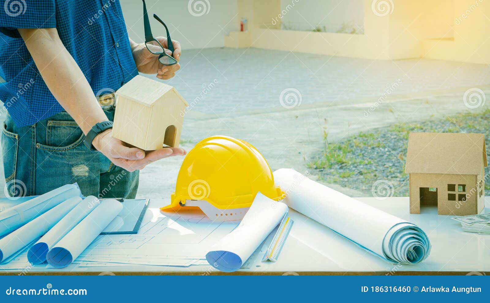 An Engineer Holding a House Plan and a Table Top with a Pattern and an ...
