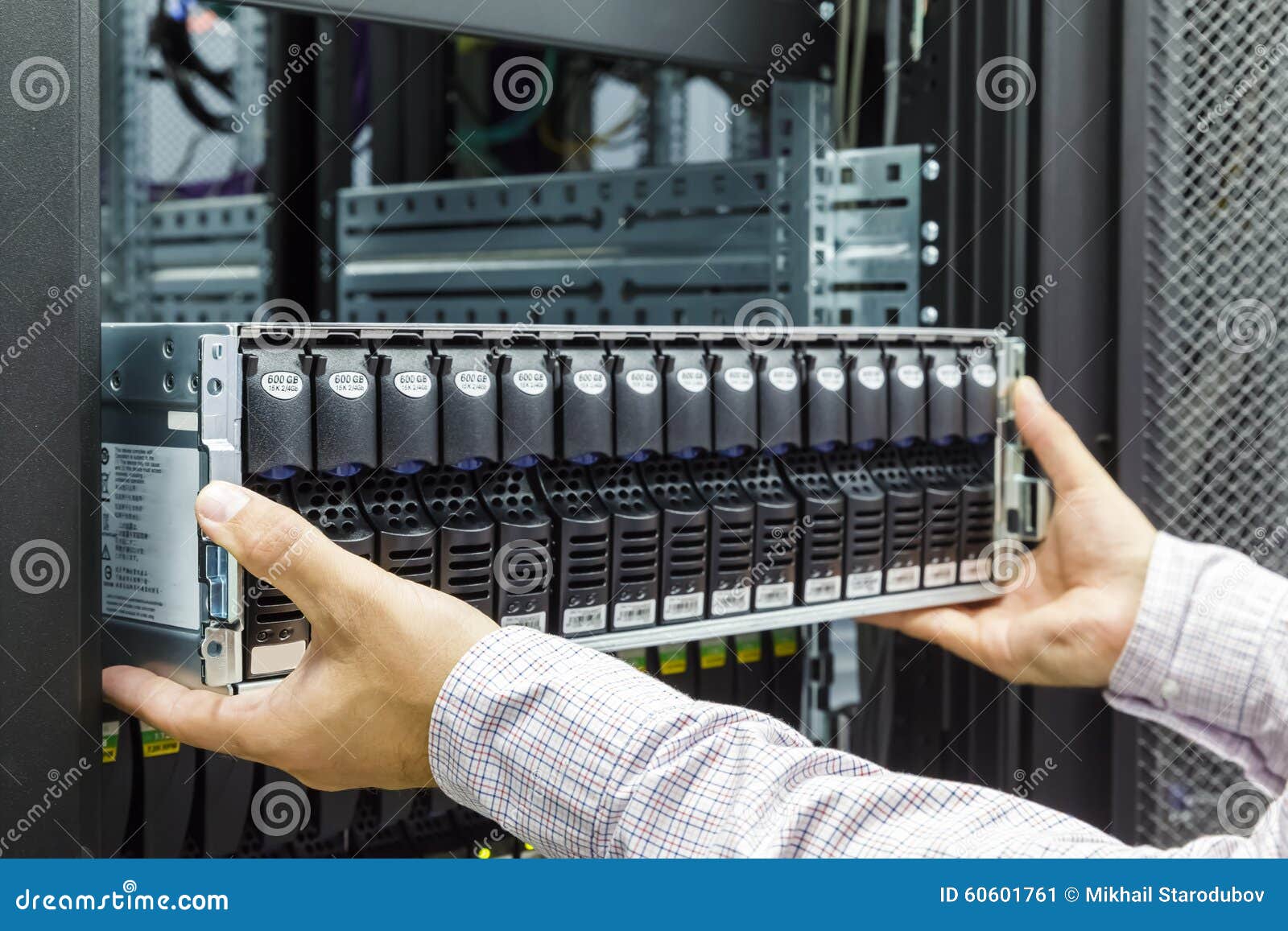 The Engineer Installs The New Equipment In The Server Rack Of The Data ...