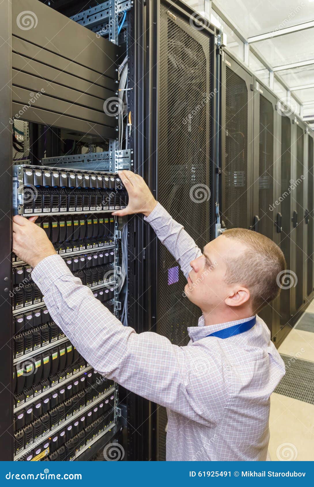 The Engineer Installs The New Equipment In The Server Rack Of The Data ...