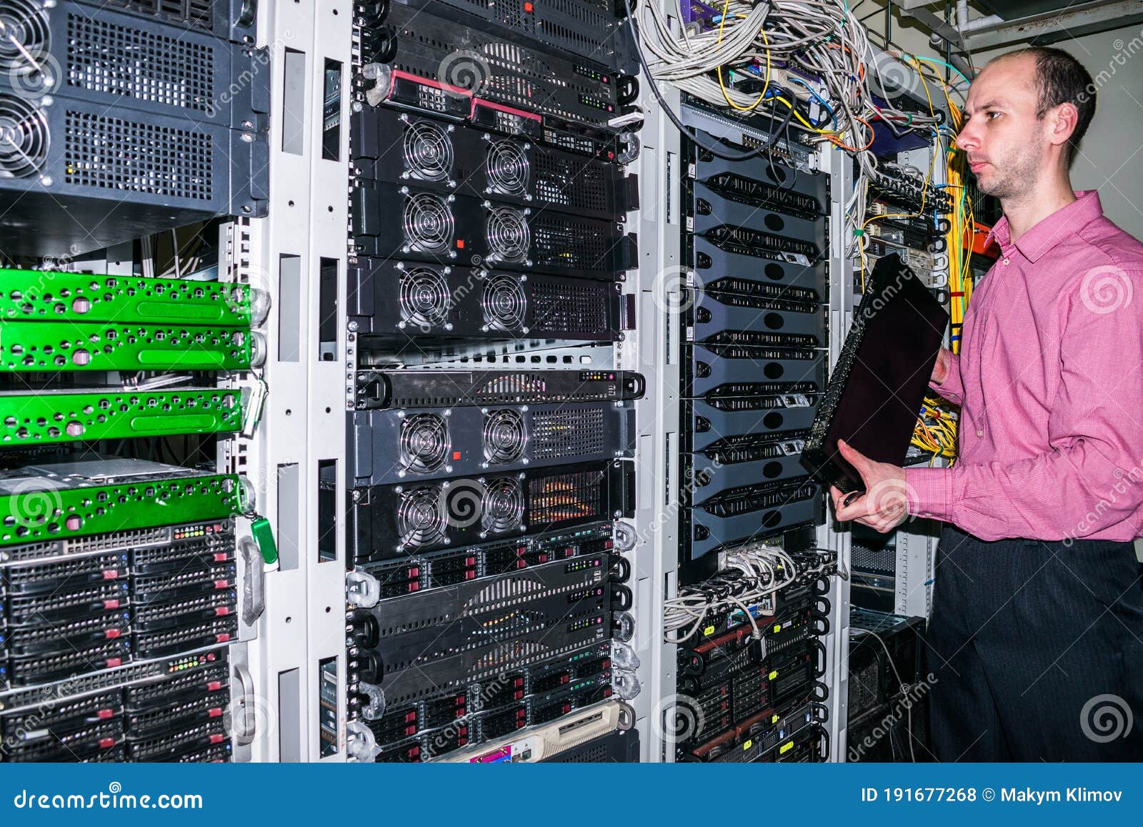 An Engineer with an Internet Switch is Near the Racks with Computer ...