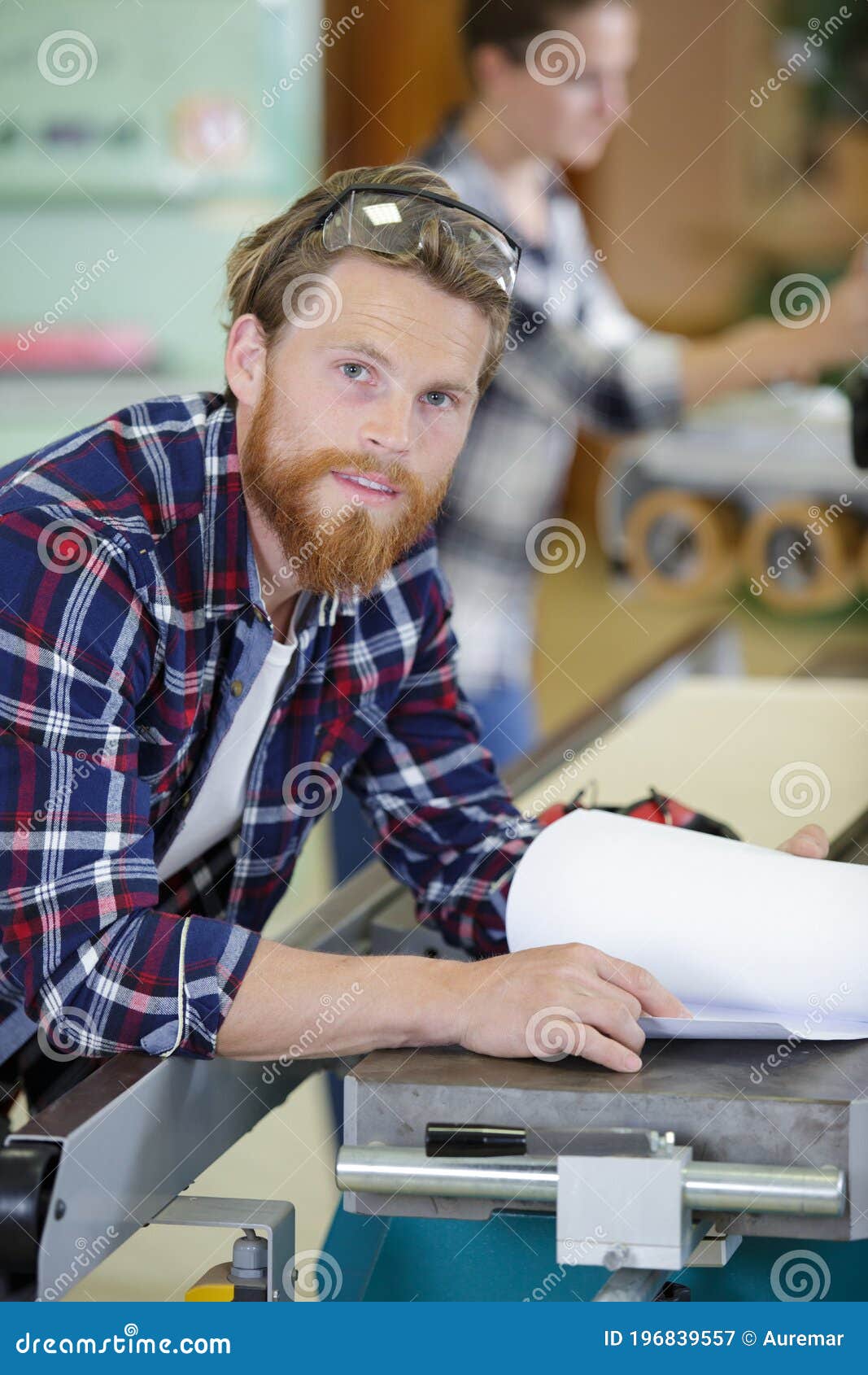 Engineer Leaning on Machinery Leafing through Paperwork Stock Image ...