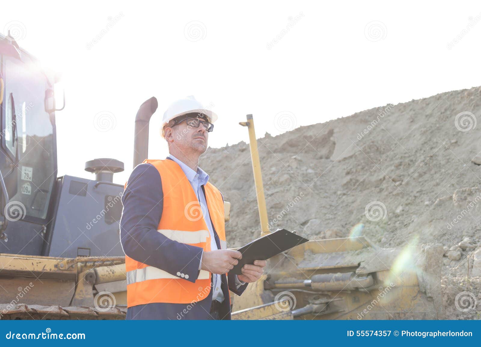 Engineer Looking Away while Holding Clipboard at Construction Site ...