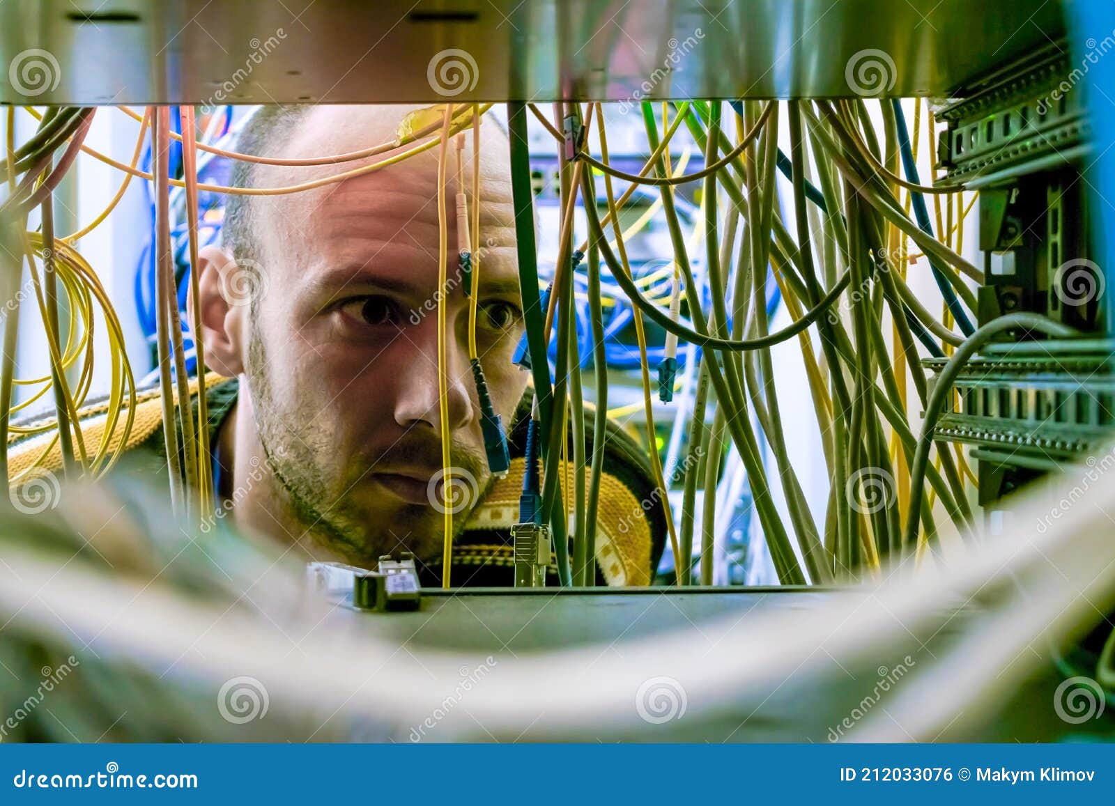 The Engineer is Looking at a Lot of Wires Entangled in the Rack Server ...