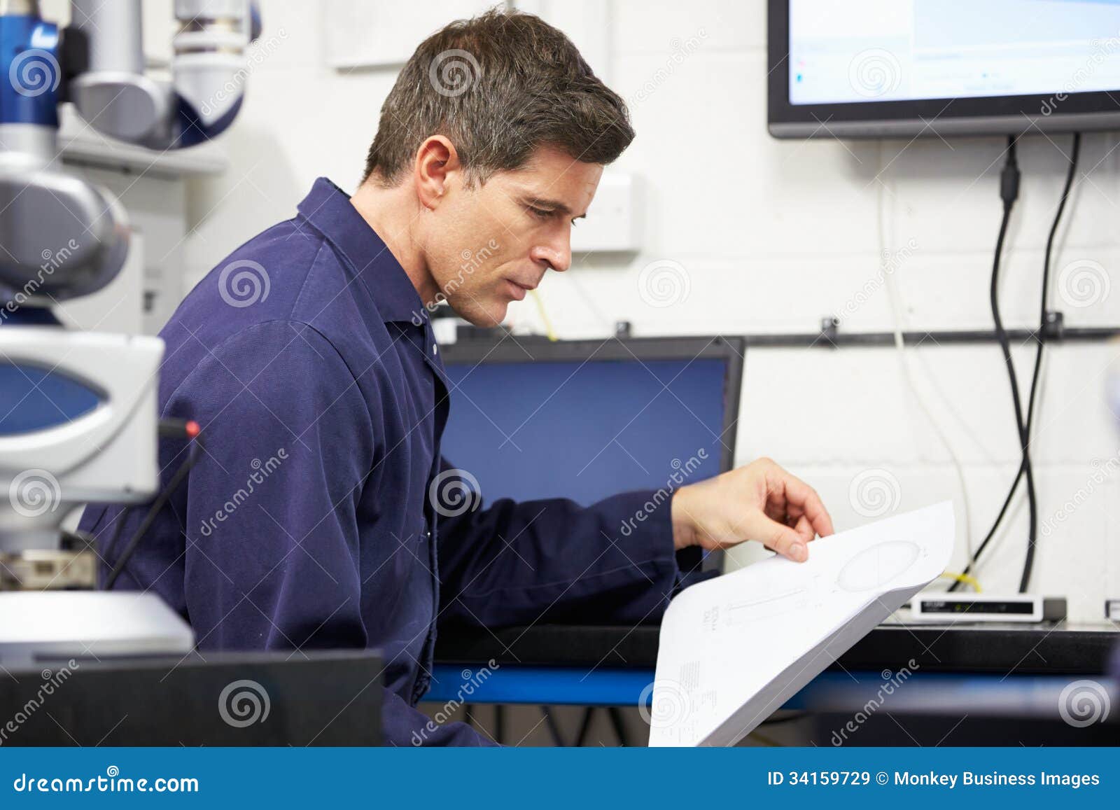 Engineer Looking at Plans with CMM Arm in Foreground Stock Image ...
